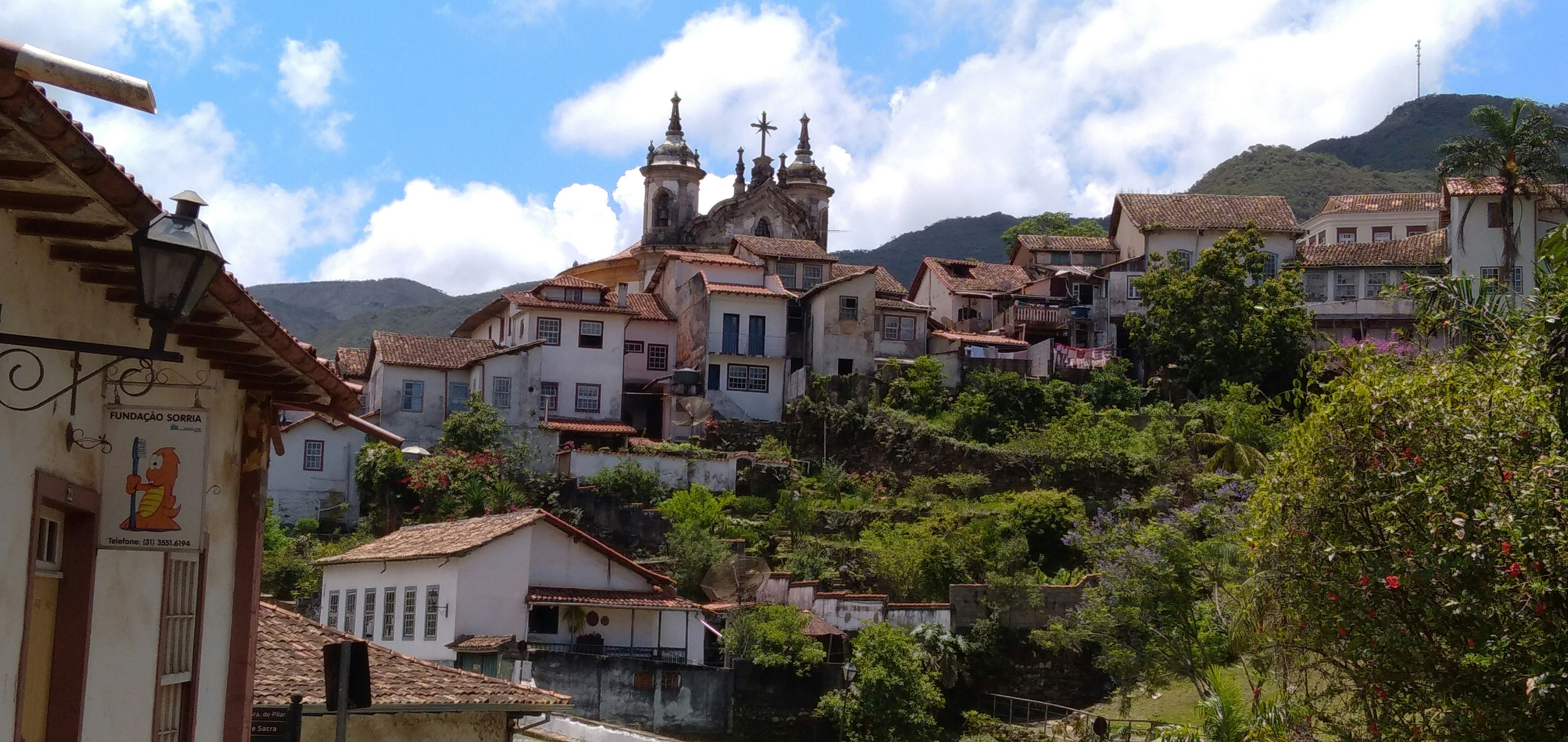 Scenic view of a hillside town with historic architecture under a bright blue sky.