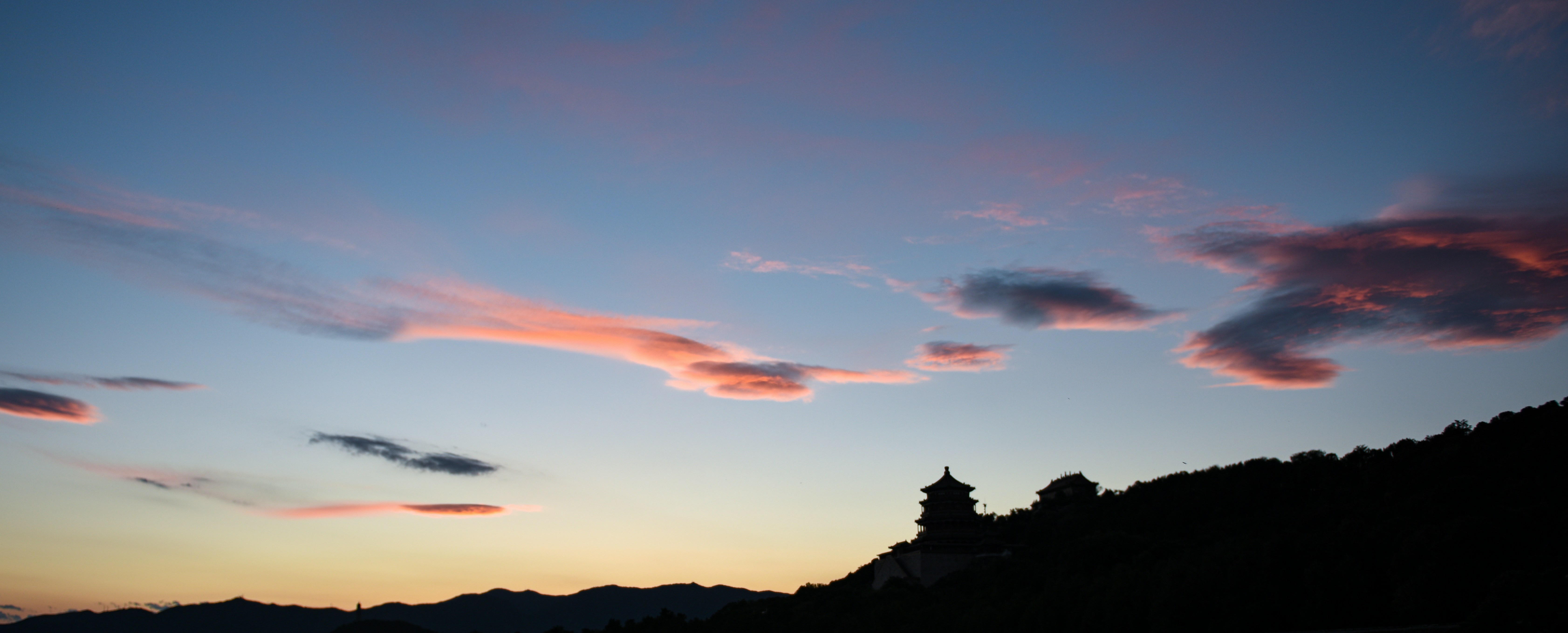 A sunset with clouds and mountains in the background photo – Free ...