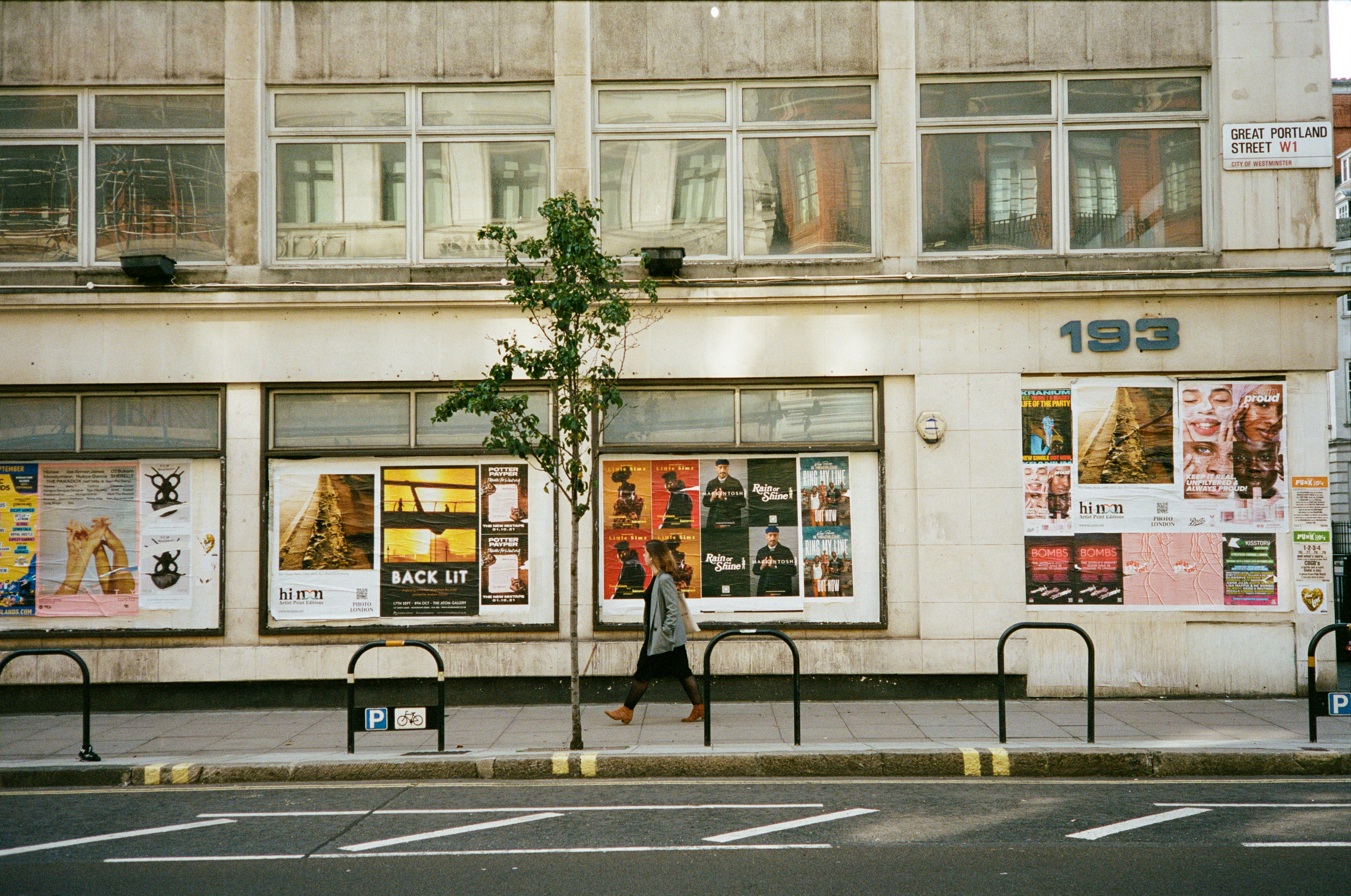 A person walking past a building with posters on it photo – Free Uk ...