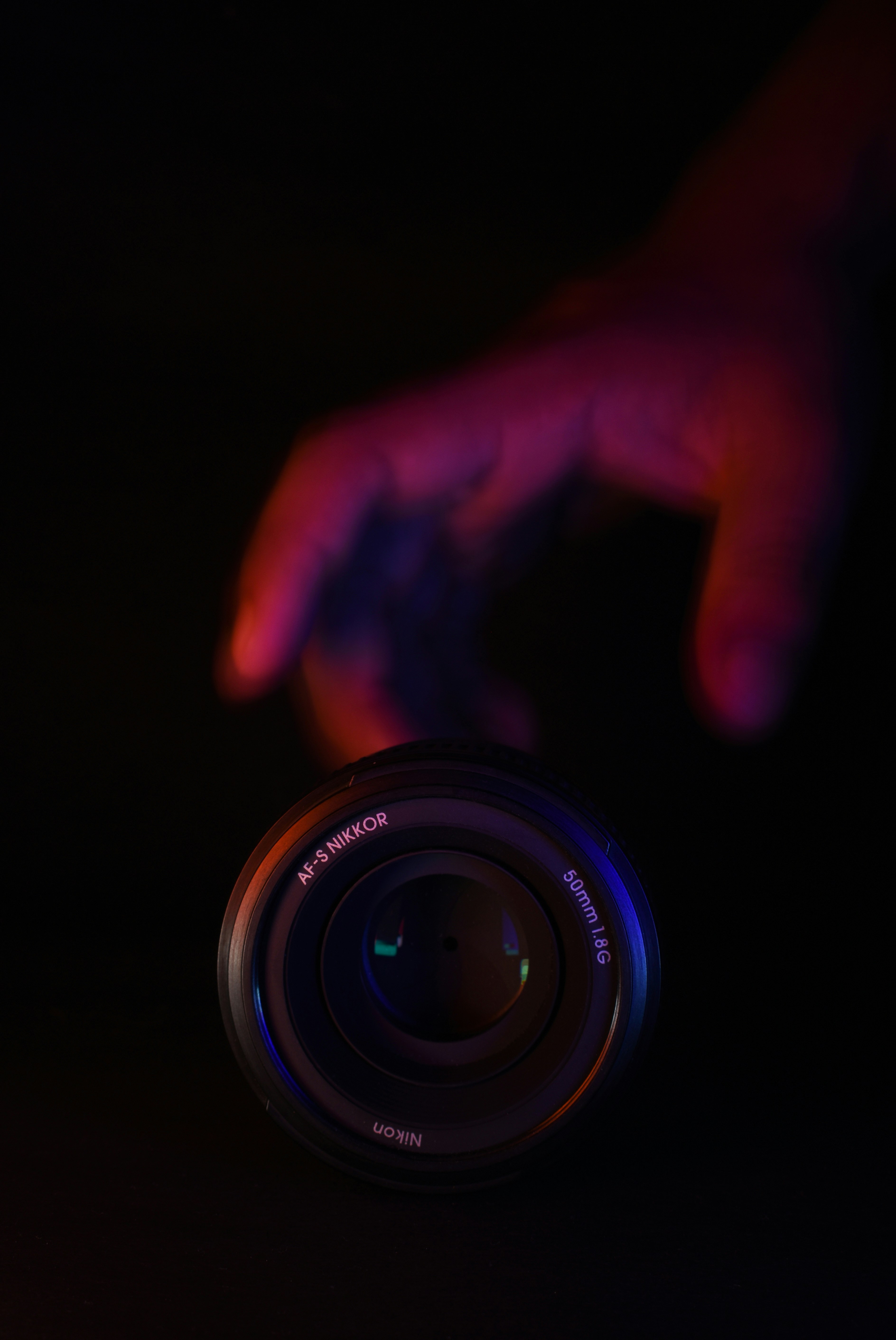 A hand holding a camera lens in the dark photo – Free Human Image on Unsplash