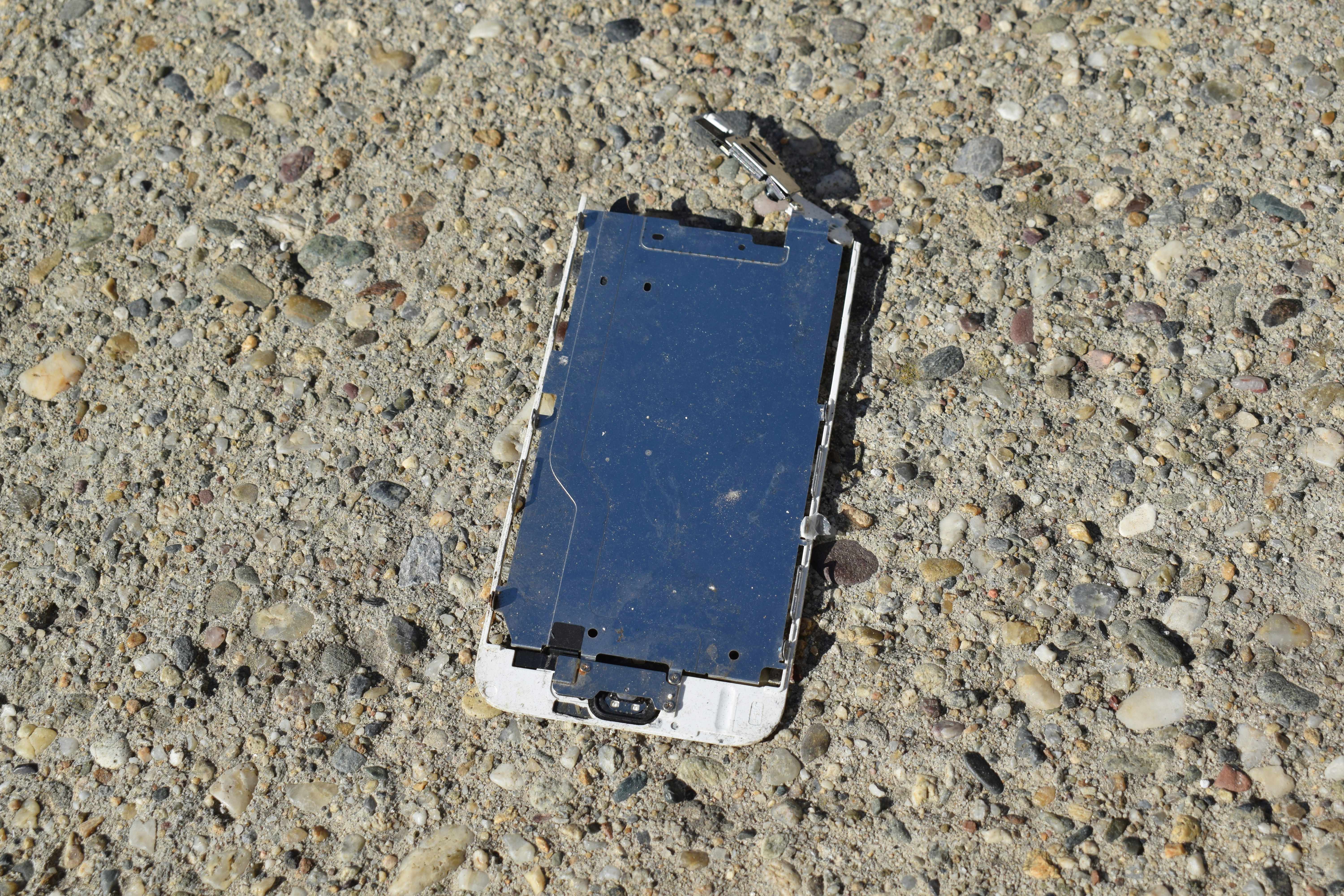 A broken cell phone laying on the ground photo – Free Blue Image on ...