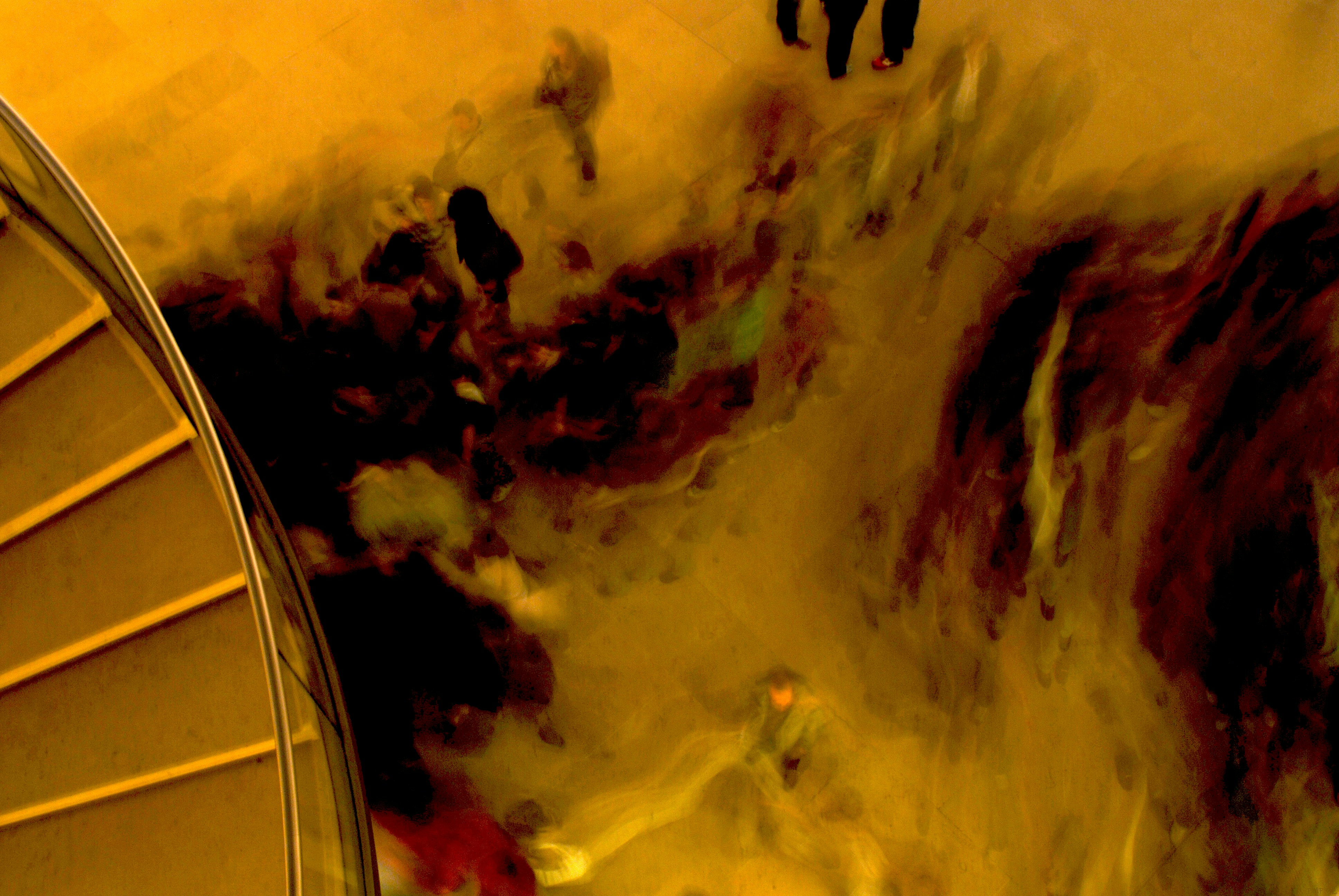 Abstract depiction of a bustling space with blurred figures and a spiral staircase, conveying movement and energy. The warm tones create an inviting atmosphere.