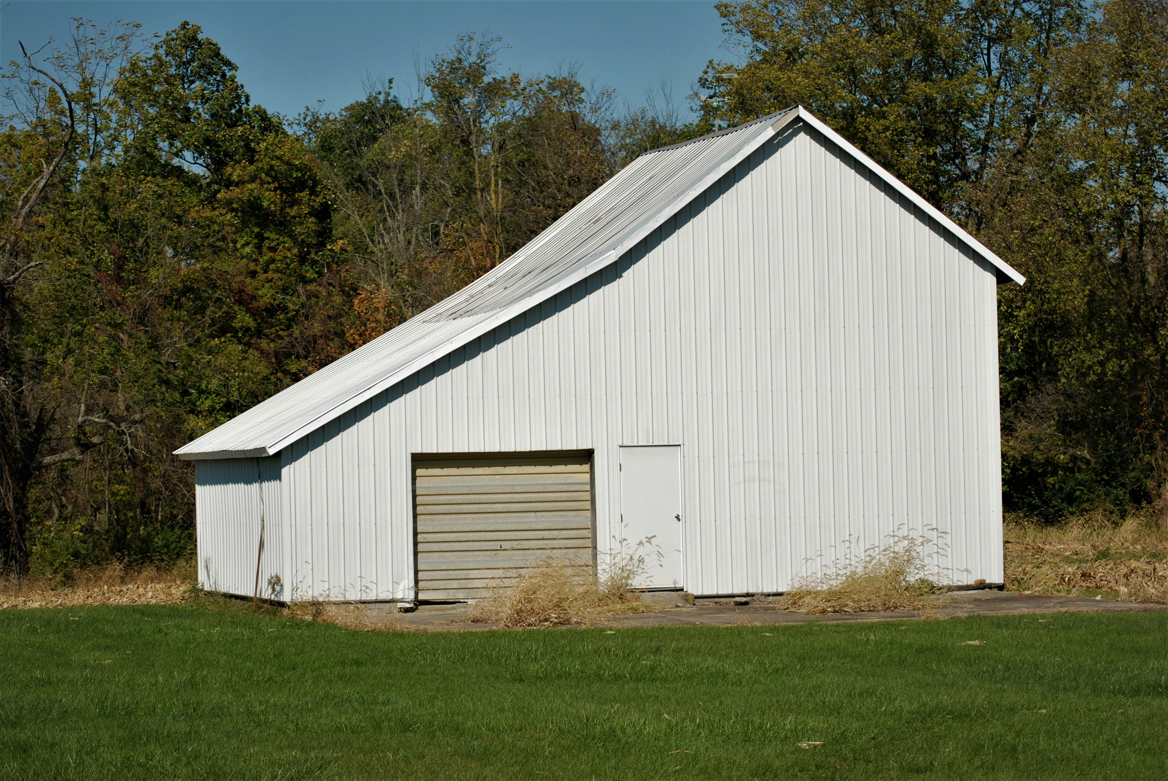 A large white barn sitting in the middle of a field photo – Free Grey ...