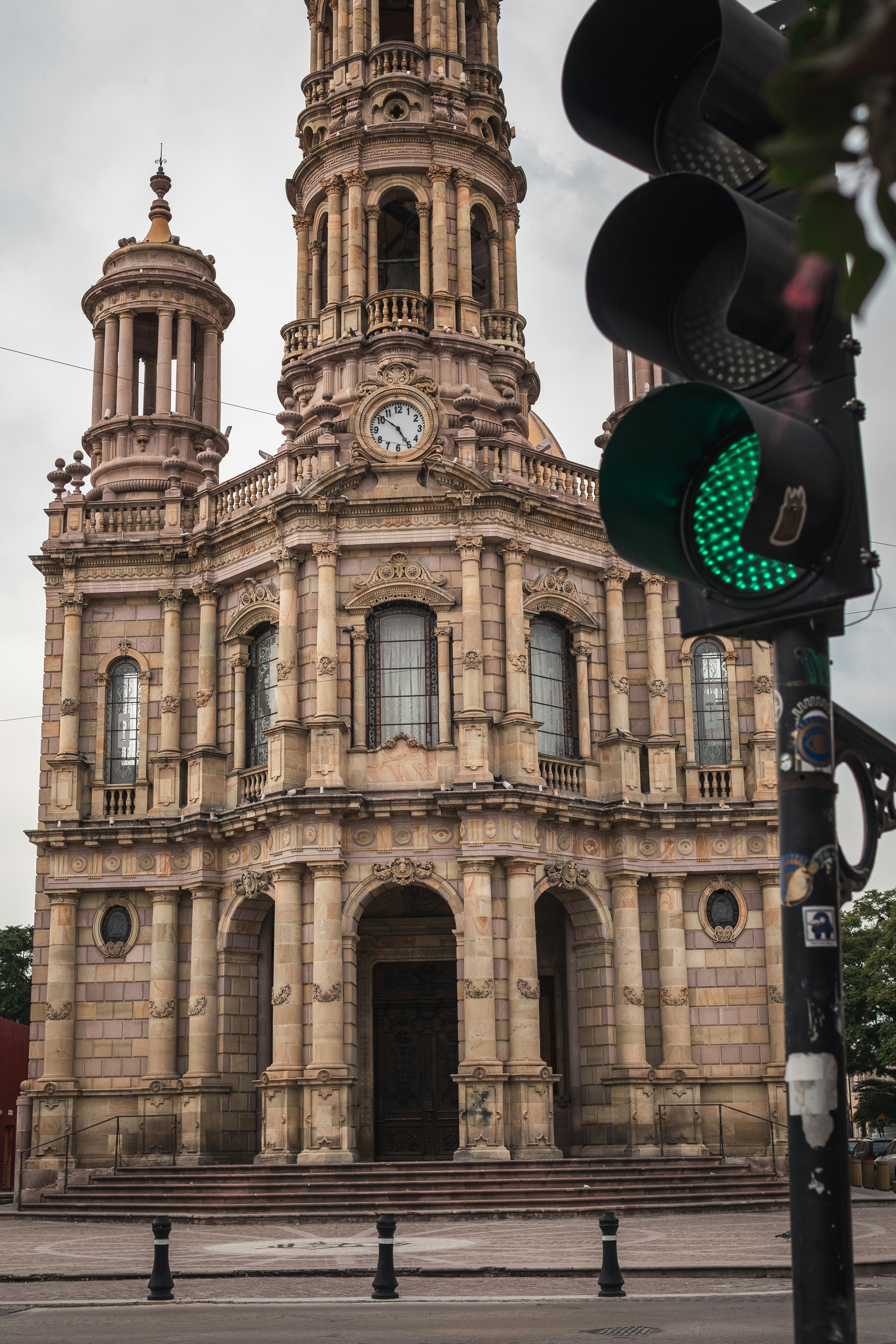 Clock-Tower Cathedral Framed by a City Green Signal