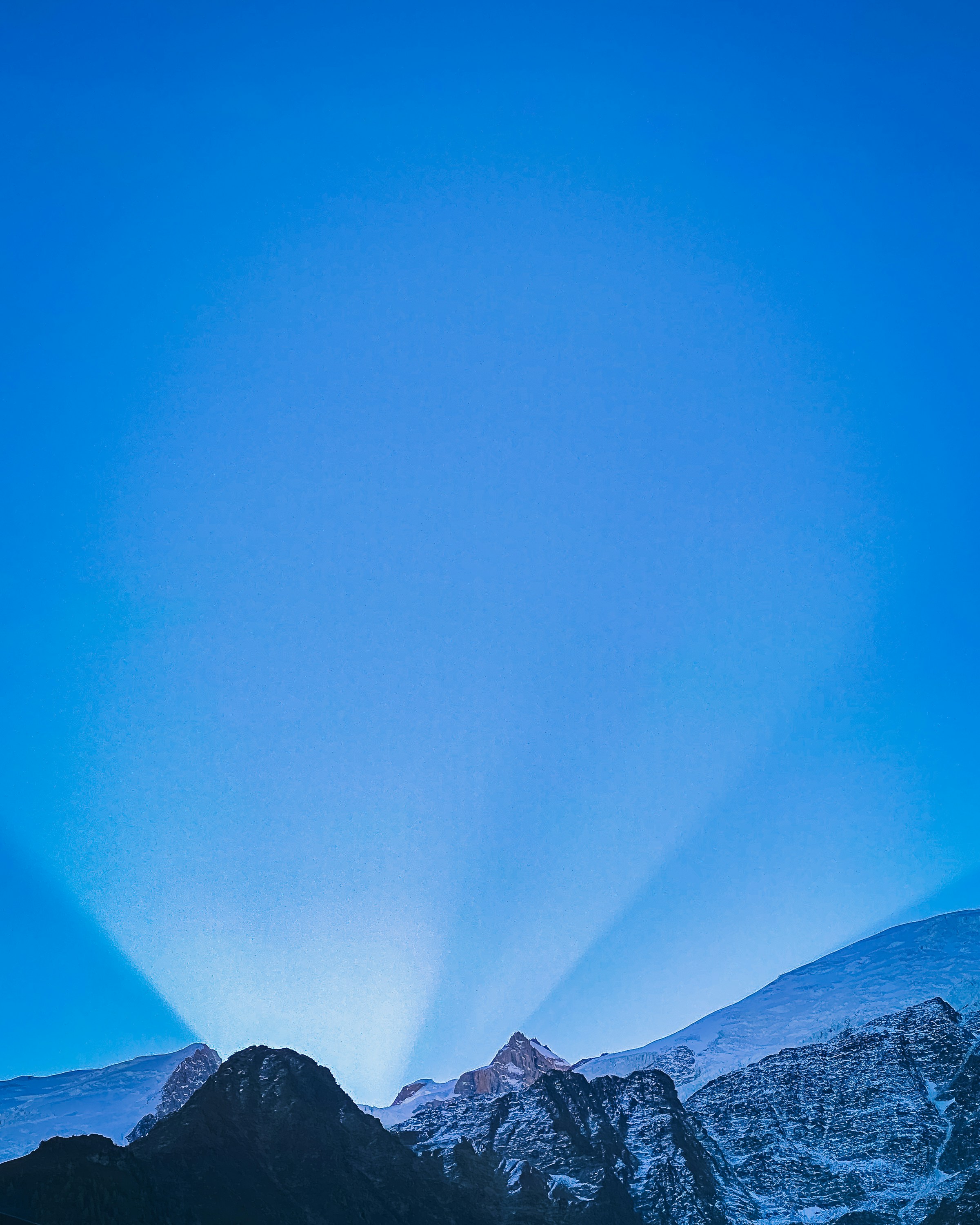Sunrise Beams Over a Snow-Clad Ridge