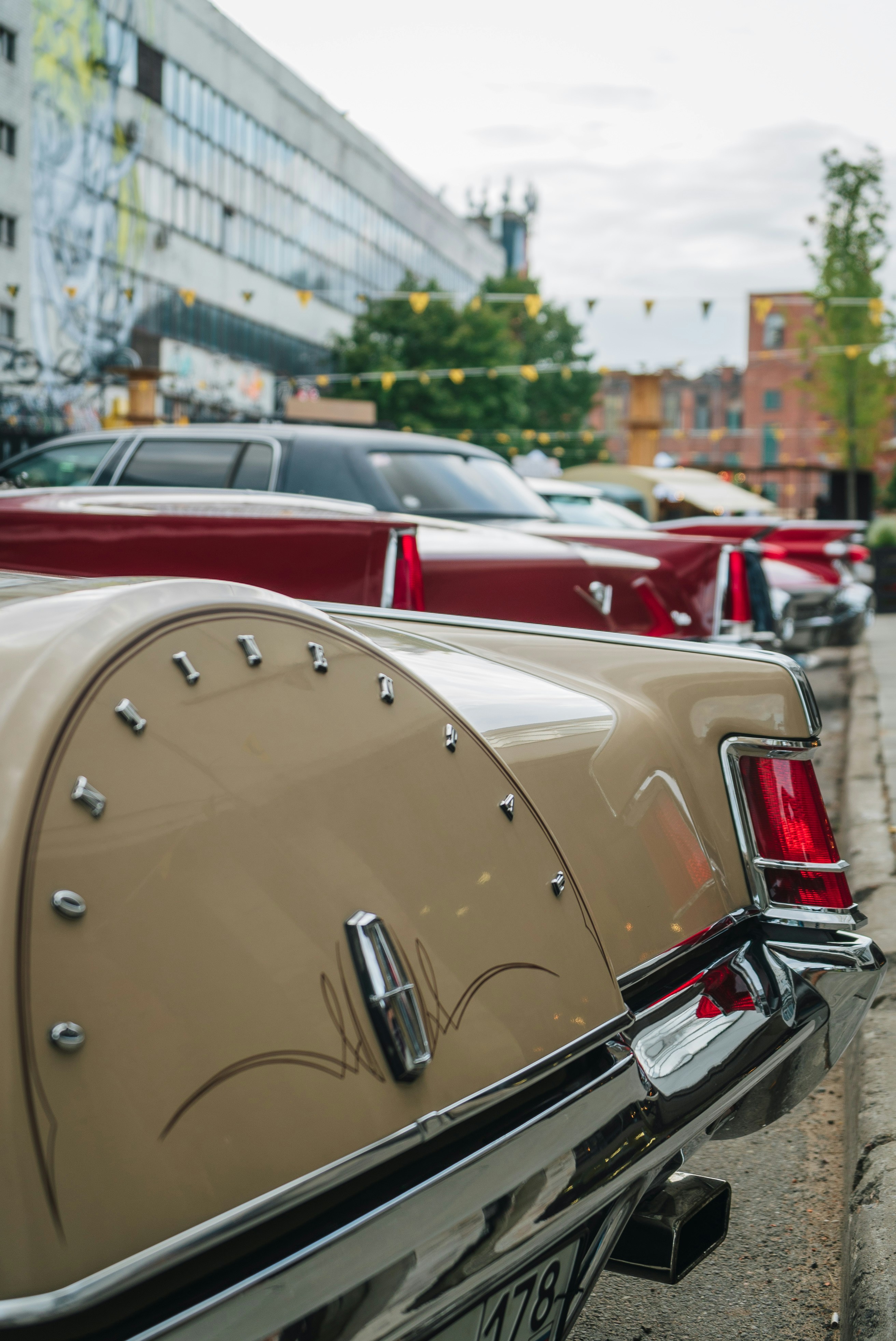 Beige Vintage Cruiser: Riveted Spare-Tire Moment Among Urban Classics