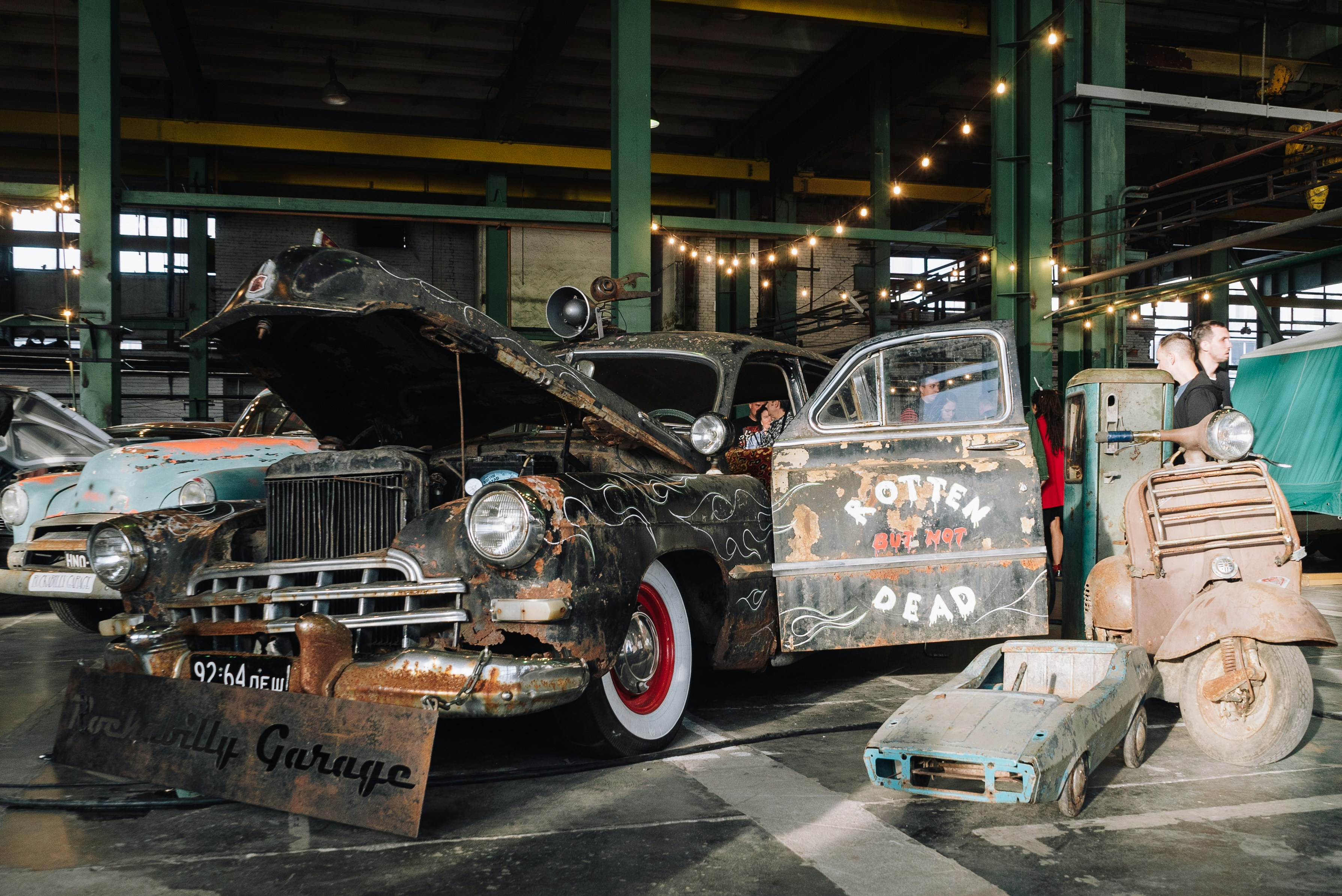 Open-Hood Survivor: A Rusted Classic in a Neon-Industrial Salvage Hall