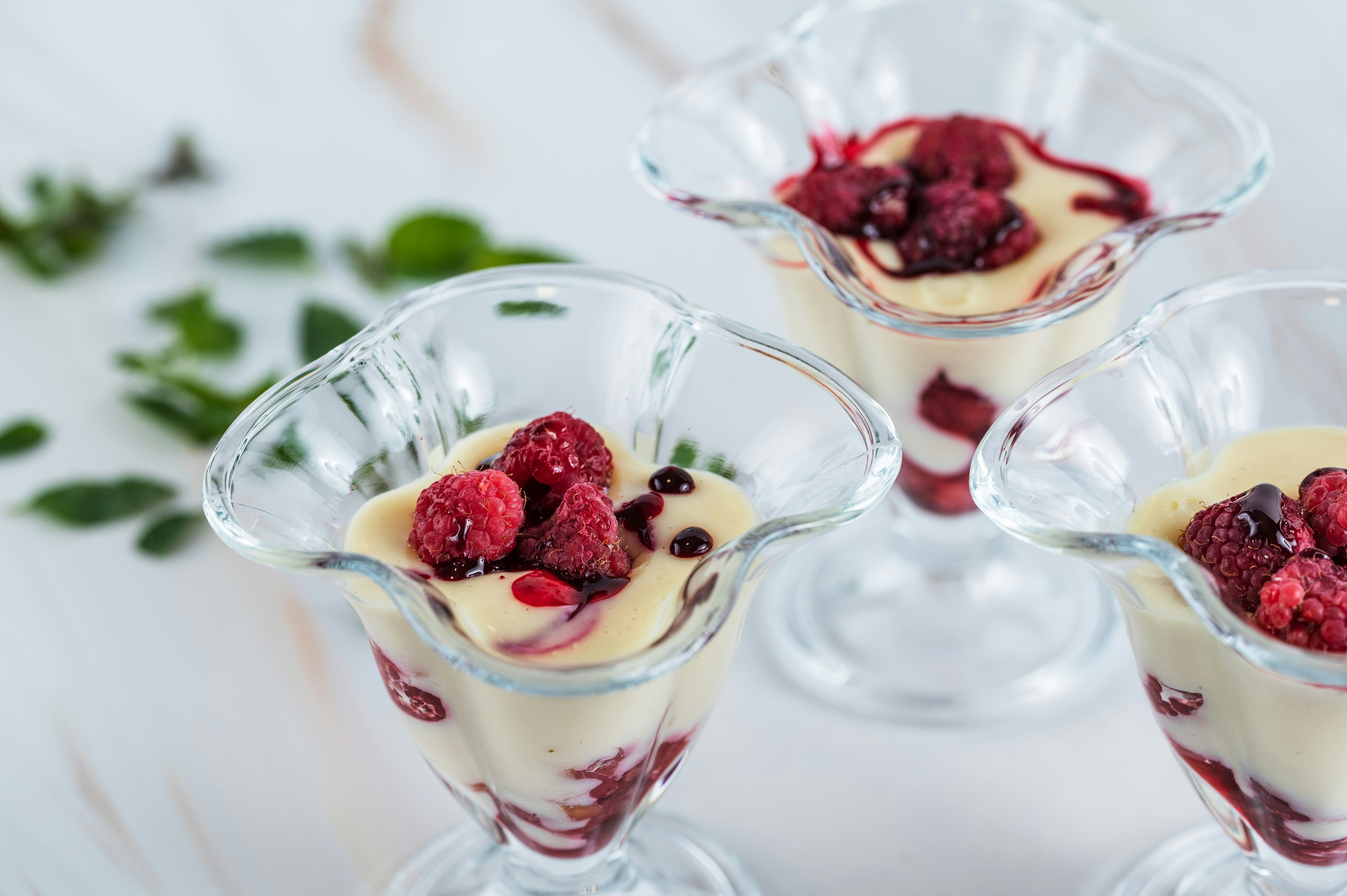 Three desserts with raspberries and cream on a table photo – Free ...