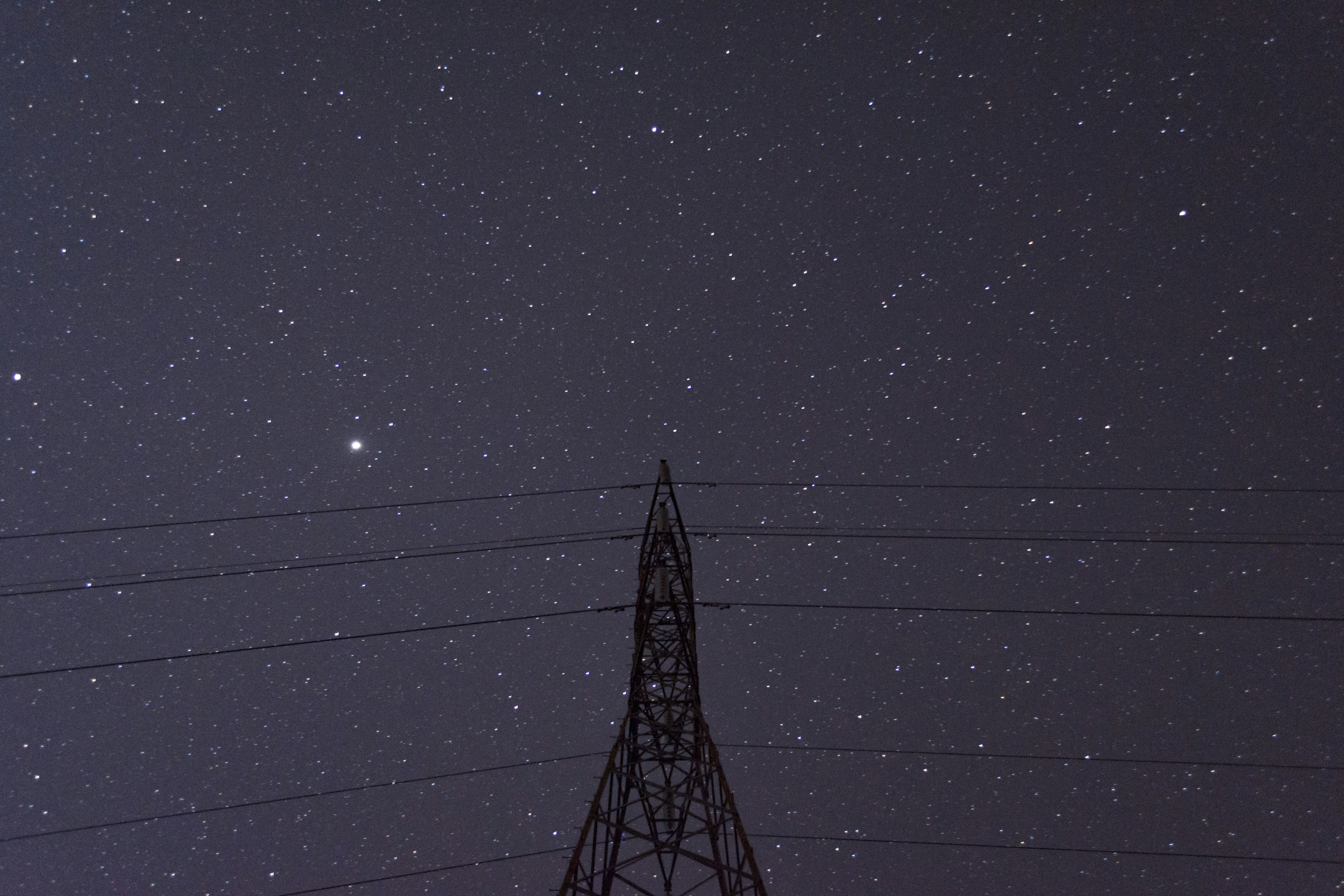 Starry Silence: A Lattice Tower Pierces the Night