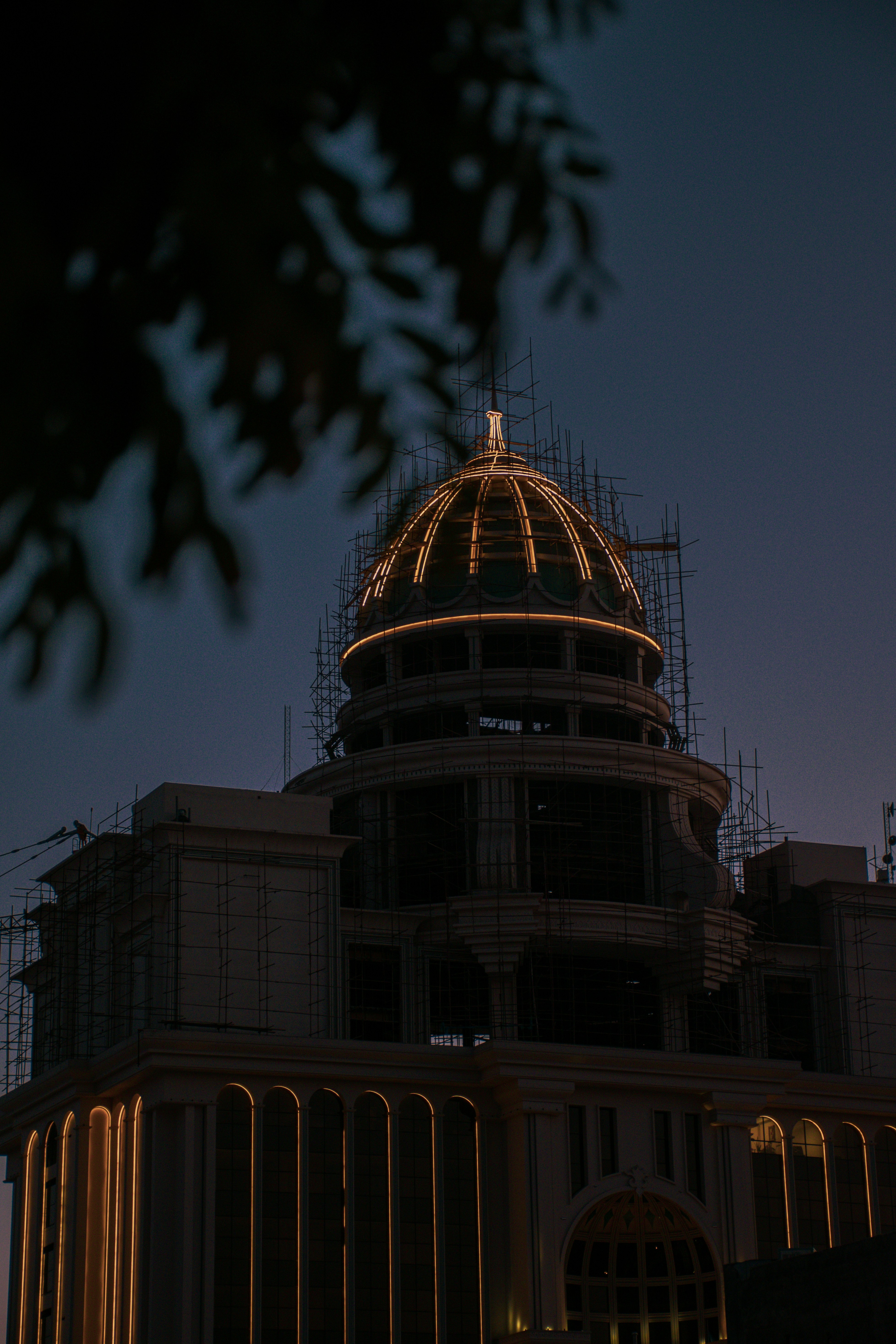 A building with scaffolding on top of it at night photo – Free Grey ...