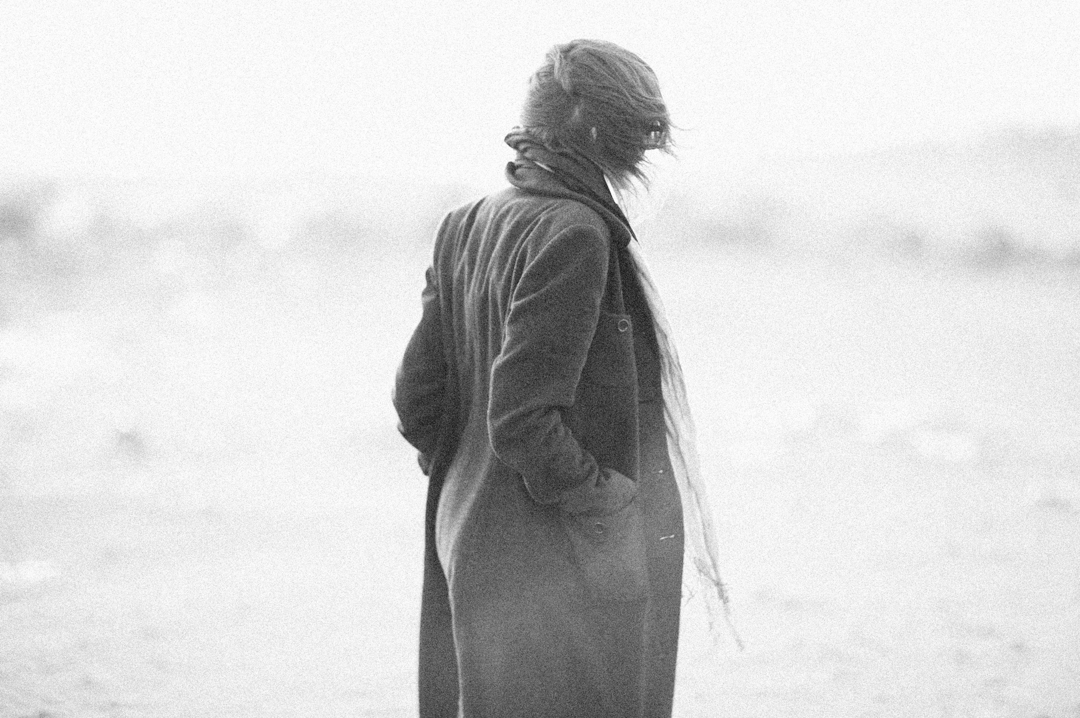 A man in a trench coat standing on a beach photo – Free Grey Image on ...