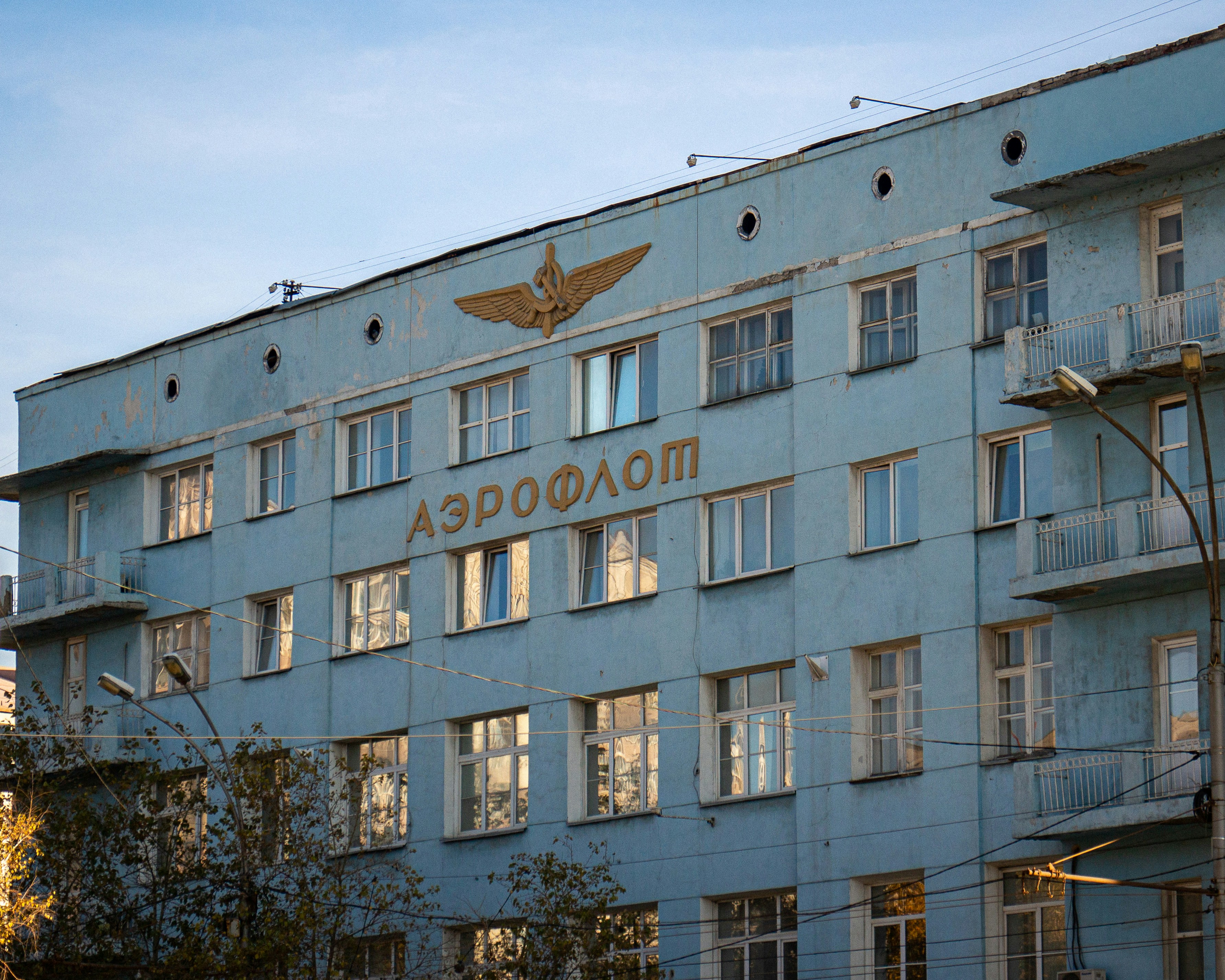 Azure Aeroflot Facade: Winged Emblem Above a Weathered Blue Building