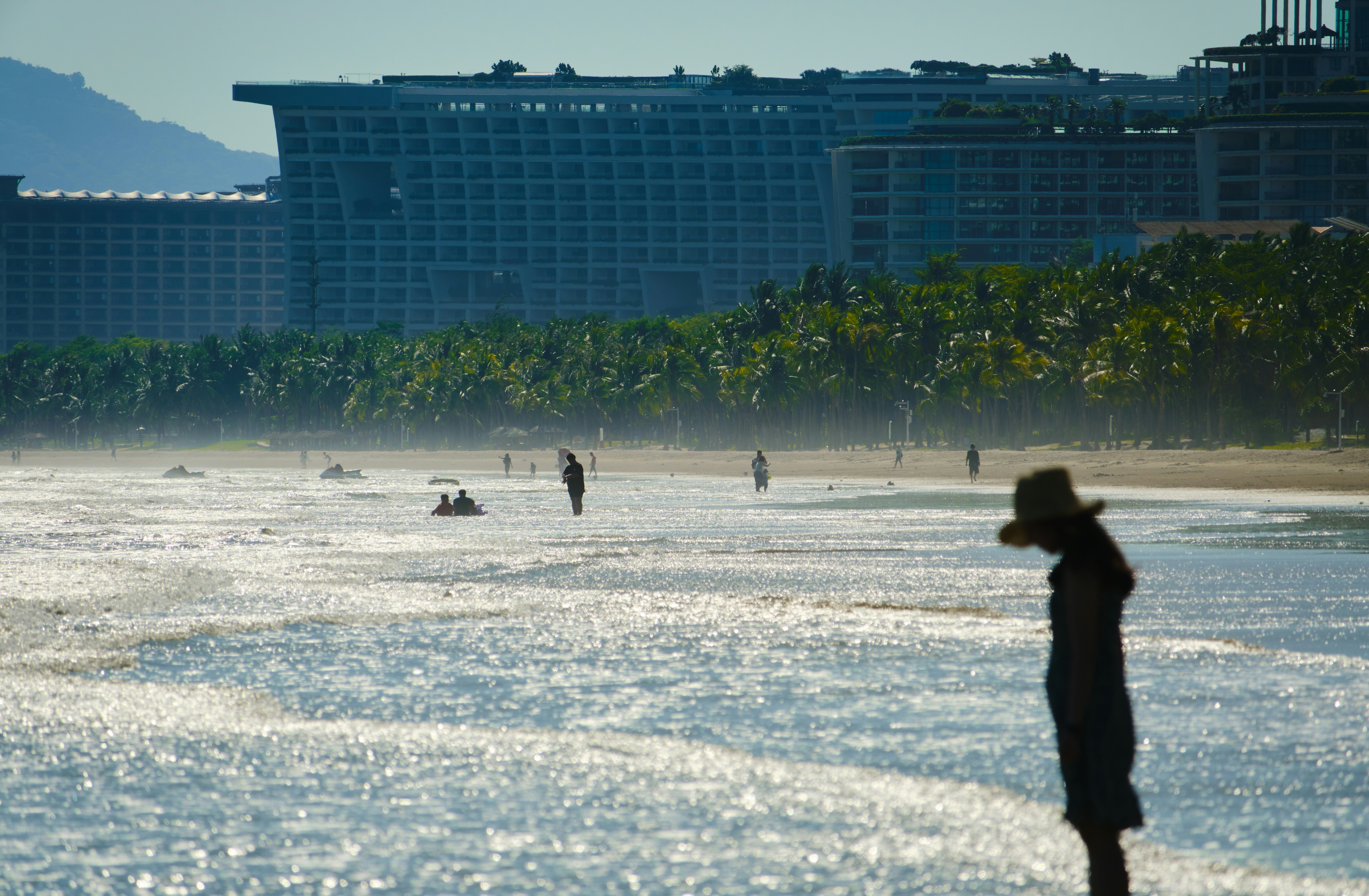 a person standing on a beach next to a body of water