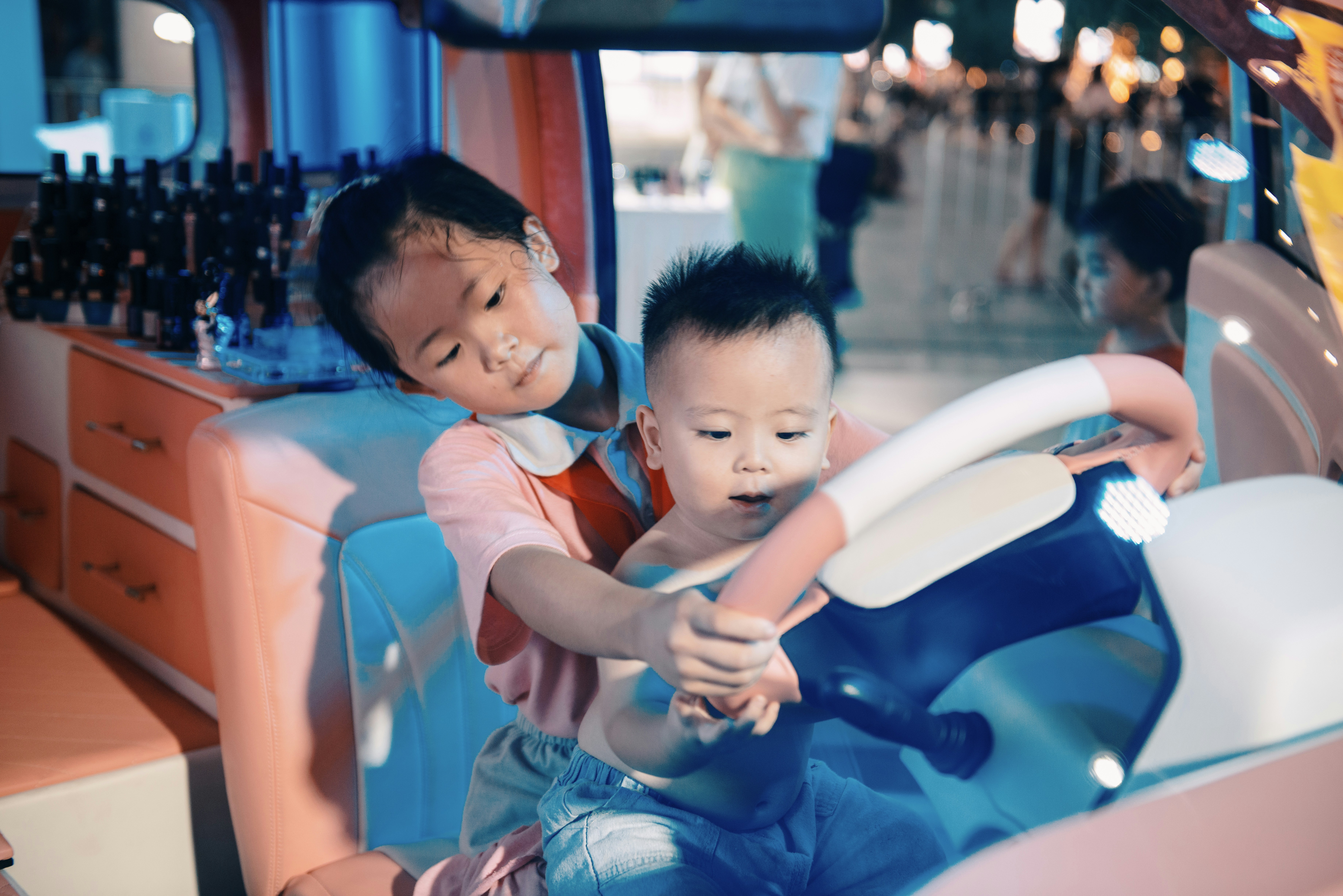 Neon Arcade Rally: A Sister Steers Her Little Brother in a Bright Ride