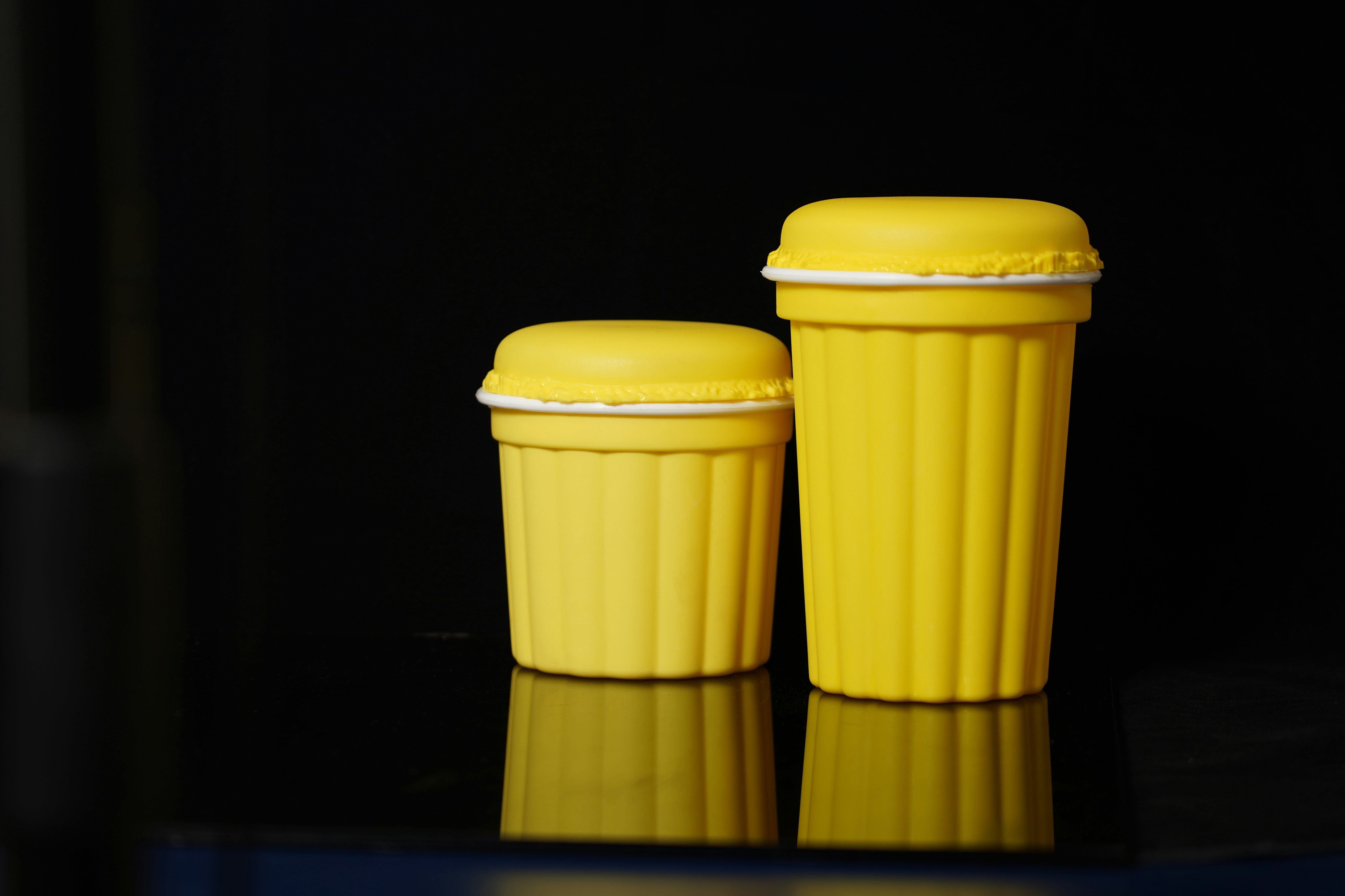 Echoes of Yellow: Dual Canisters on a Velvet Black Stage
