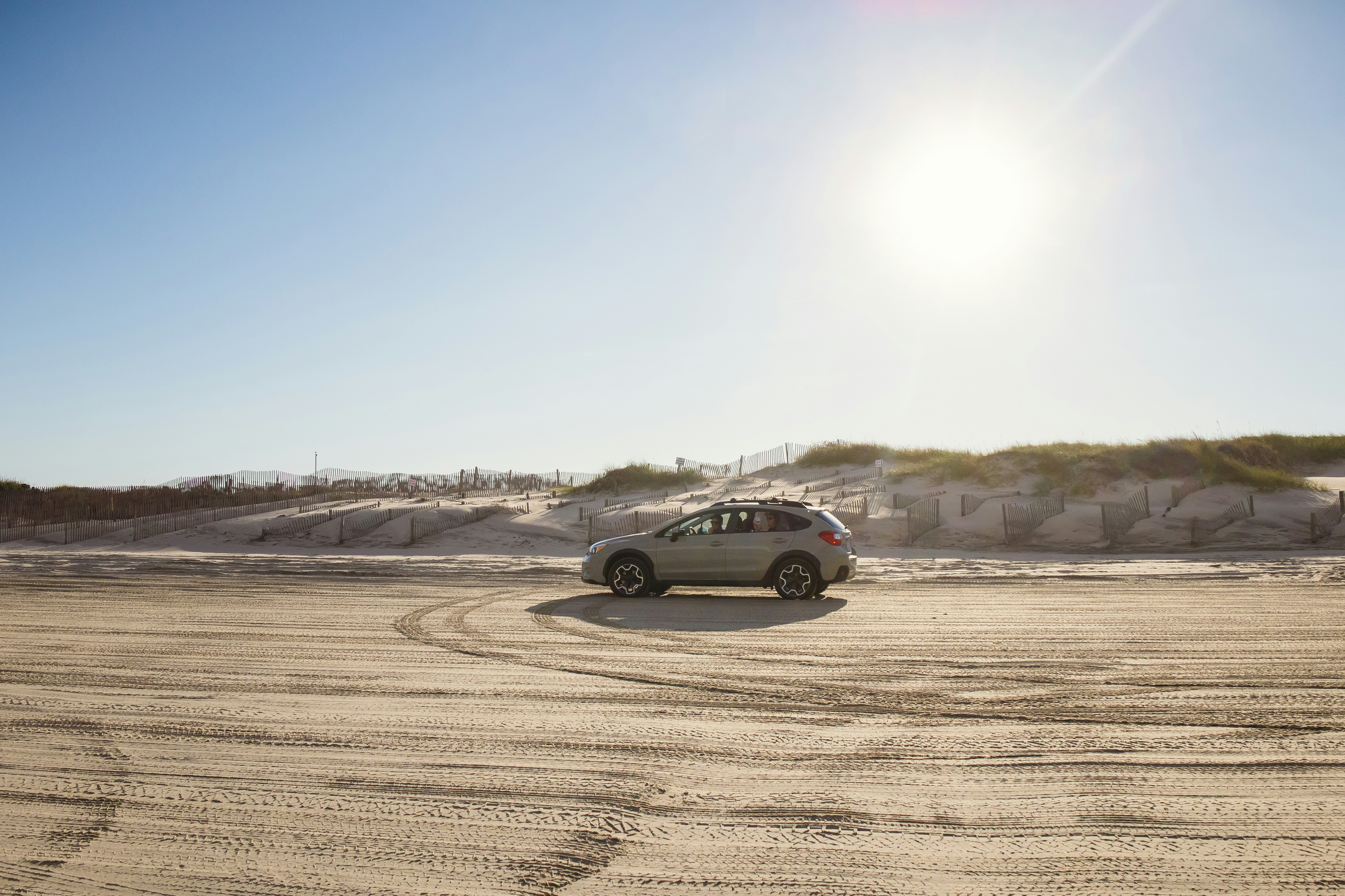 A small car driving down a sandy road photo – Free Usa Image on Unsplash