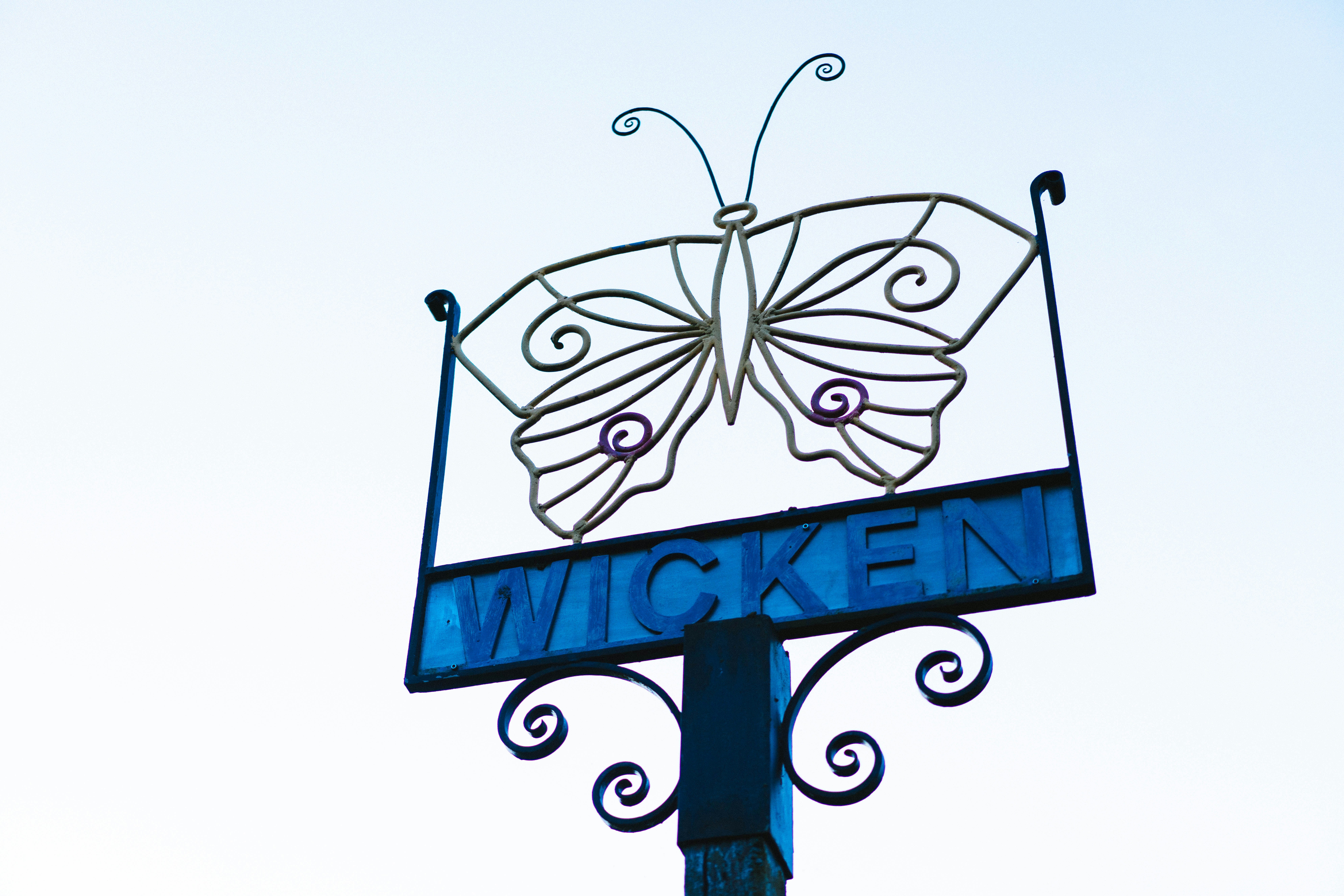 Butterfly Sign Above Wicken Lane: Delicate Silhouette Against Morning Sky