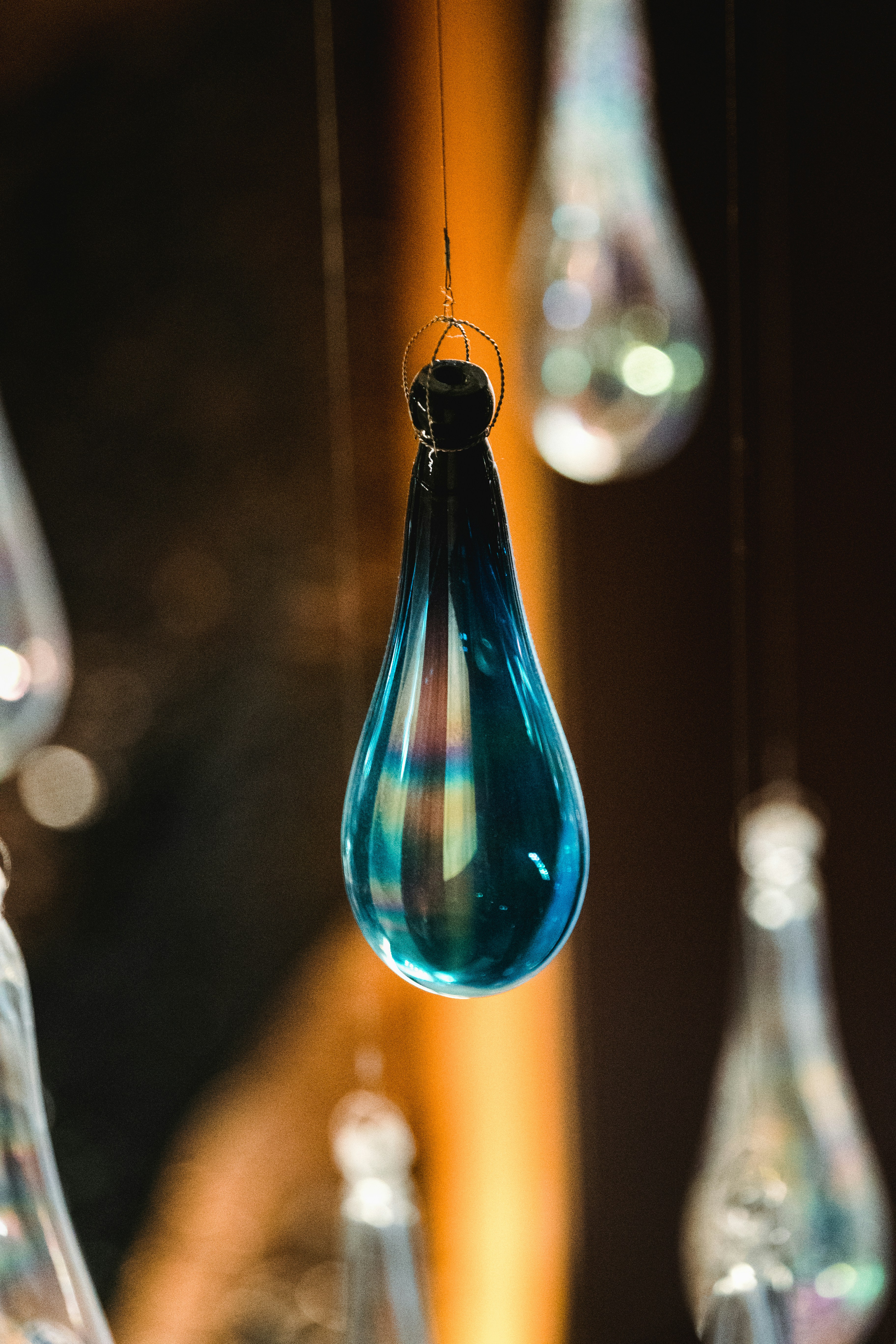 Blue Teardrop Pendant: Quiet Glow in a Velvet Backlit Scene