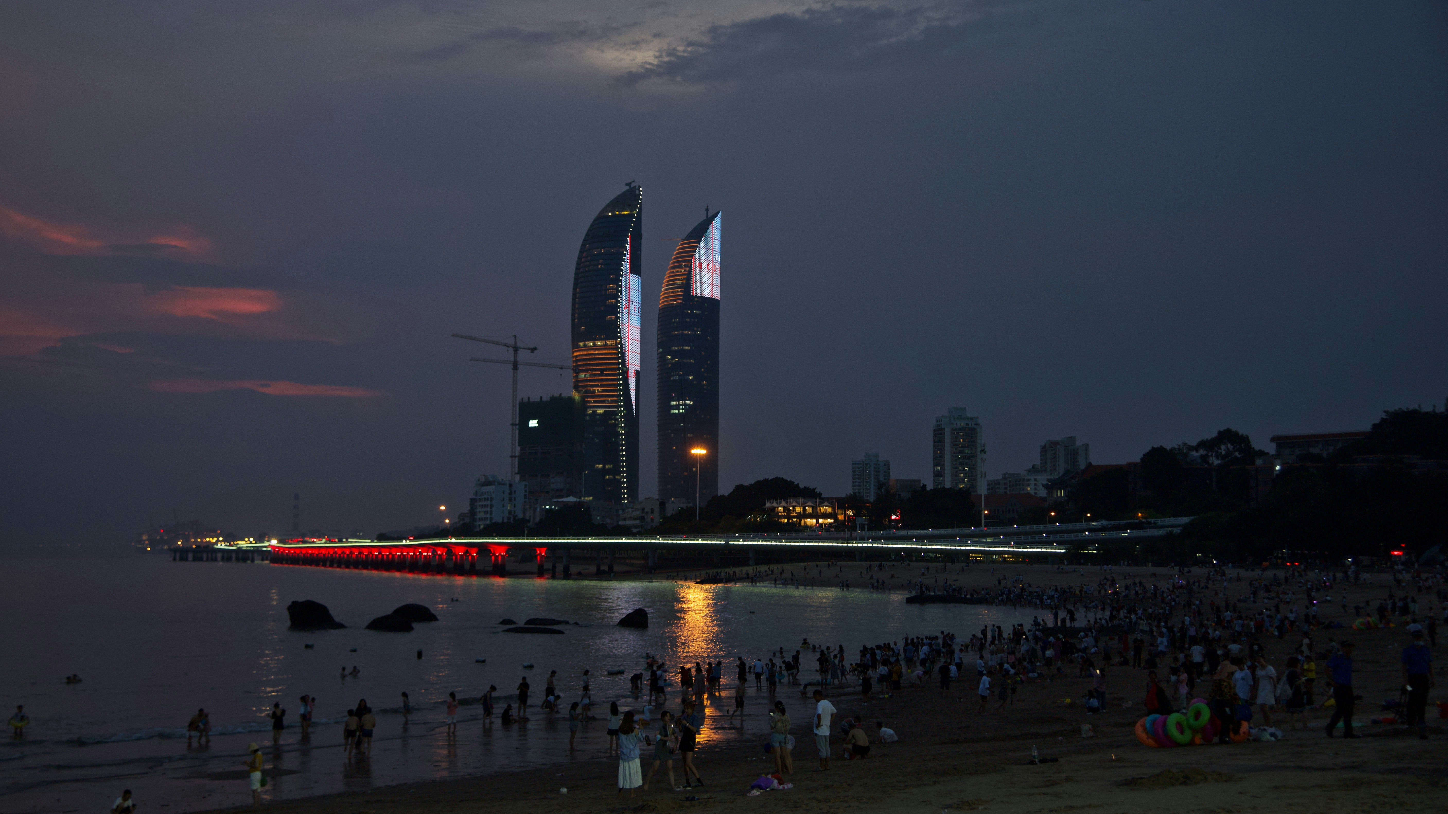Twilight Sails and a Crowded Shoreline: Reflections Along the Waterfront