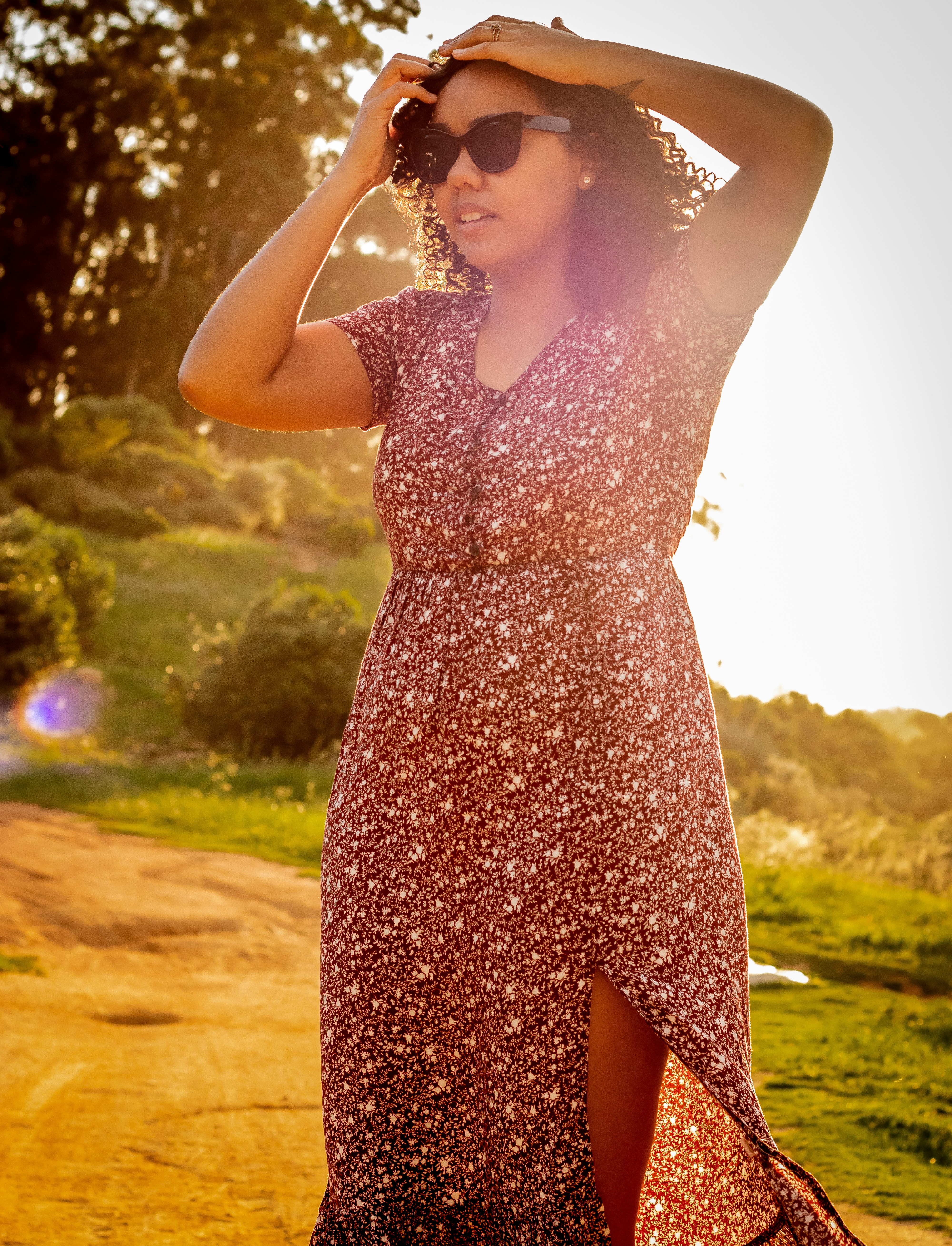 Sunlit Confidence: A Woman in a Floral Dress Stages a Golden Hour Moment