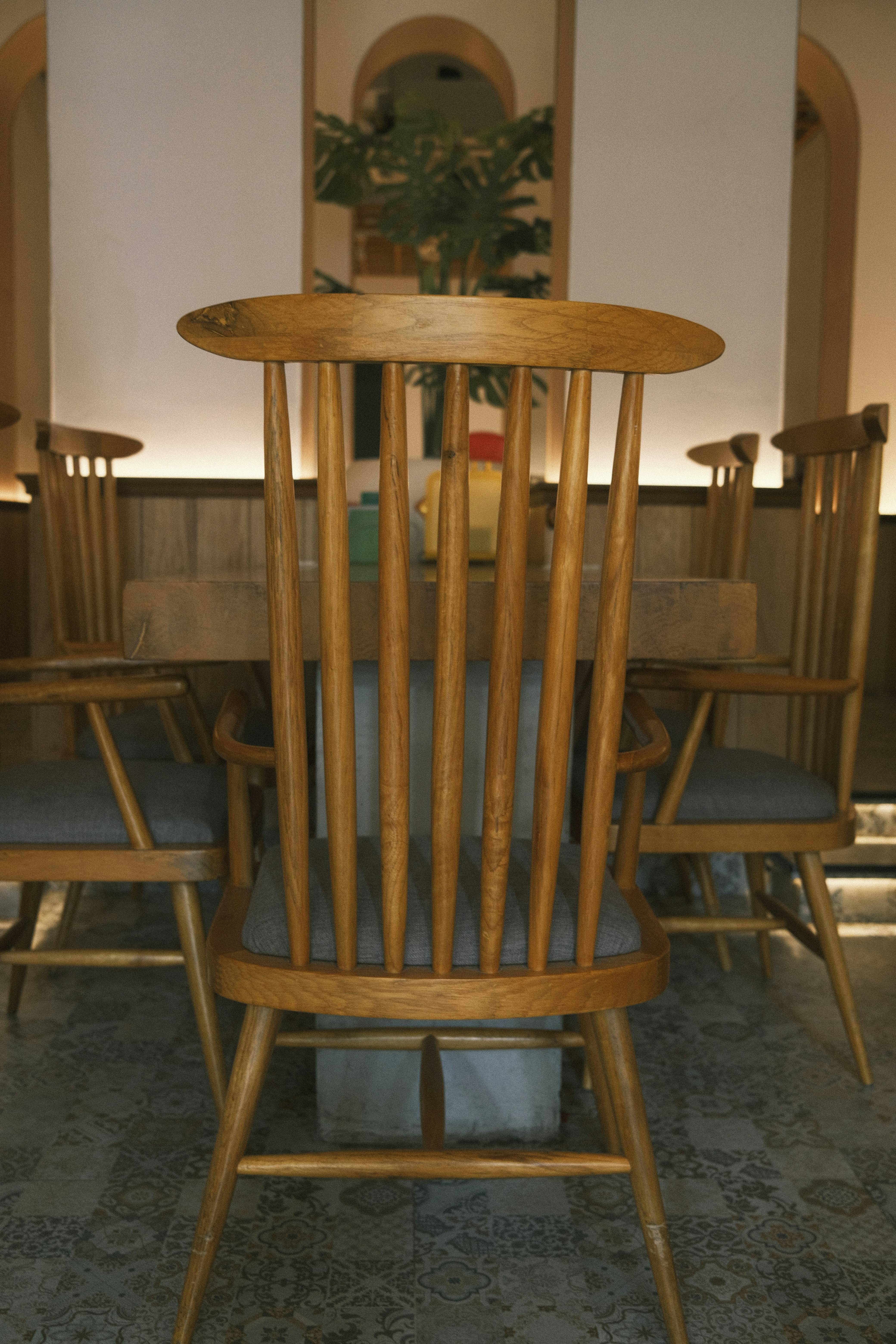 a dining room table with chairs and a potted plant
