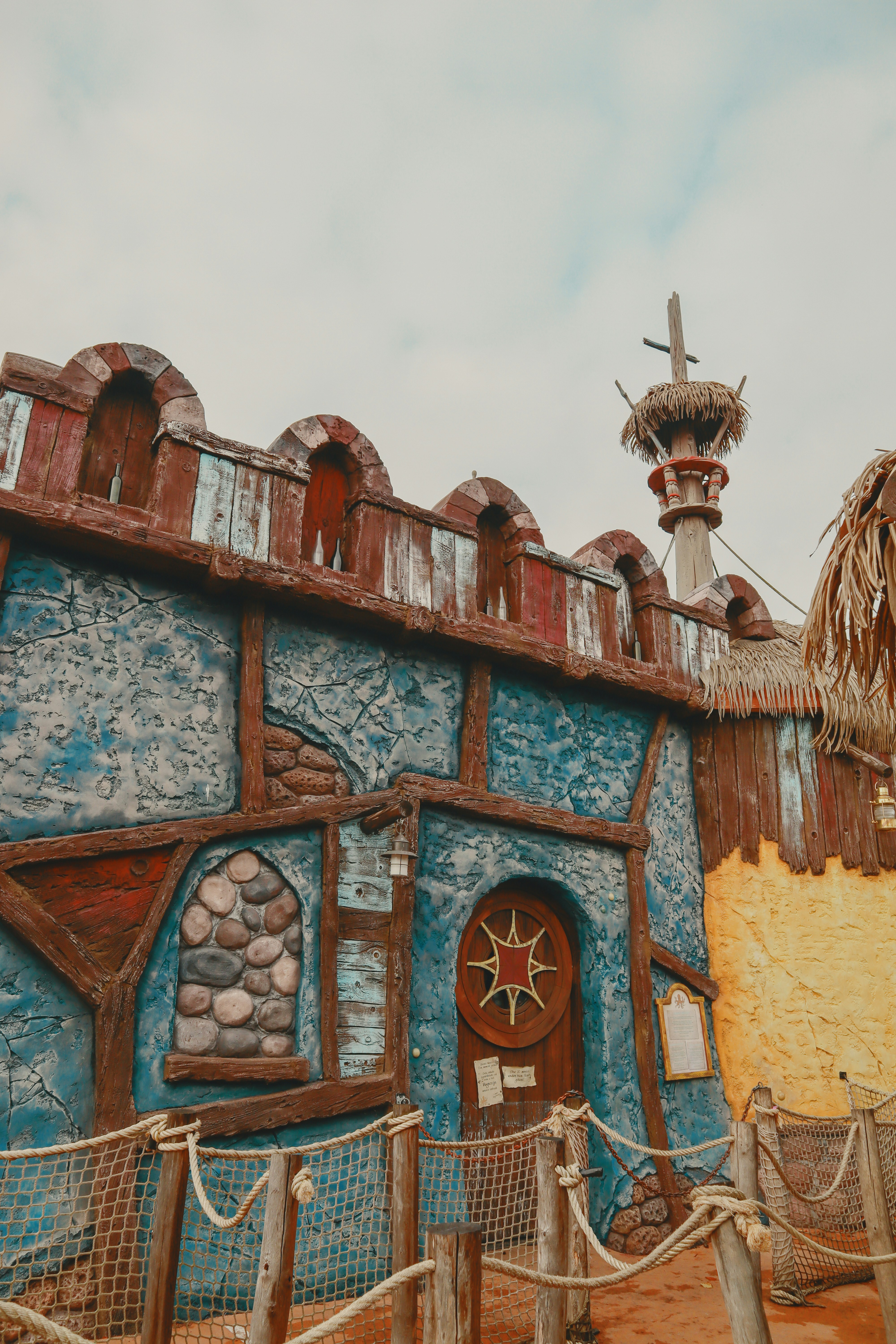 Teal Facade with Sun-Star Window and Rope-Guarded Path