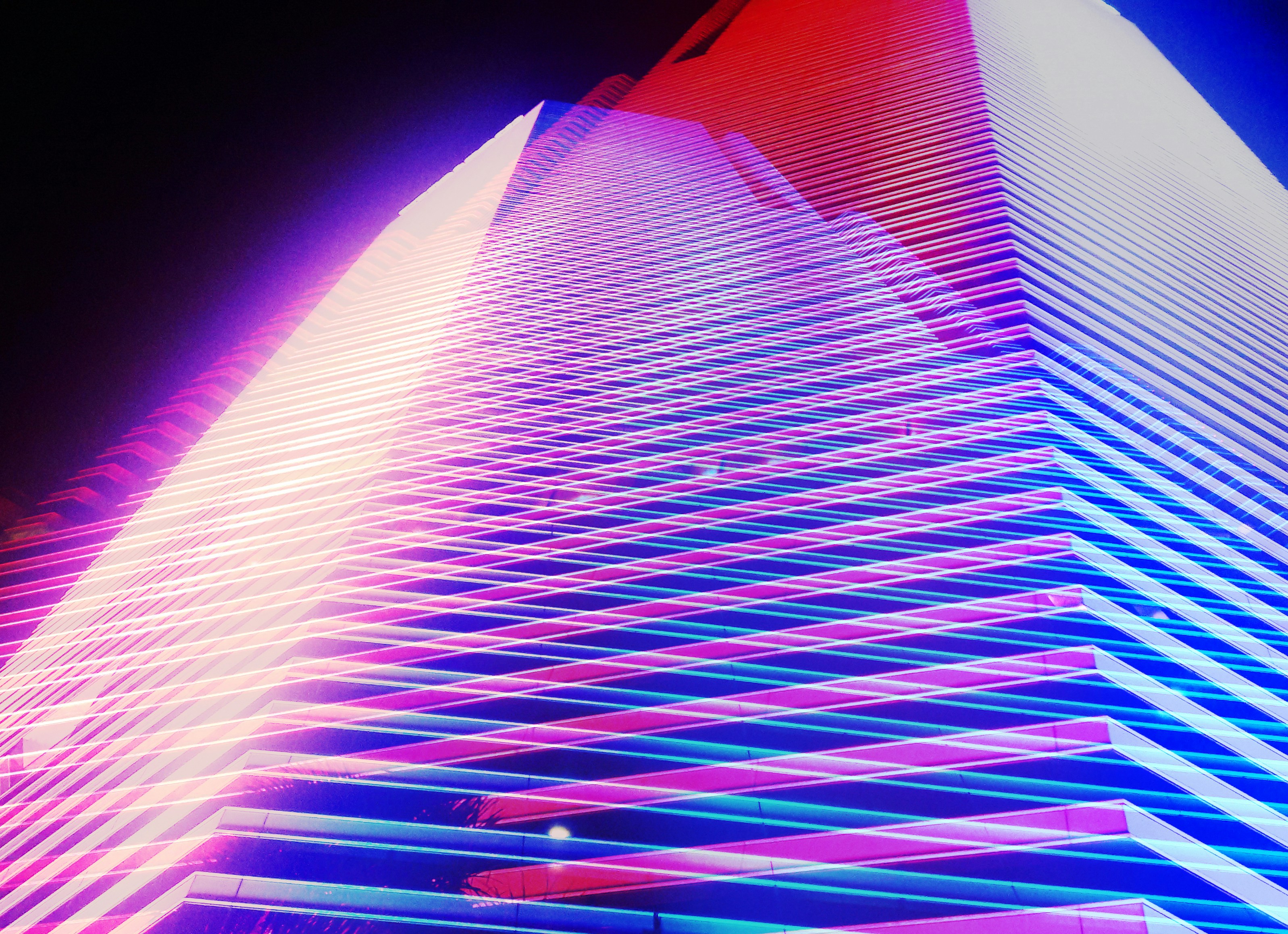 Prismatic Facade Tilt: Neon-Lit Tower at Midnight