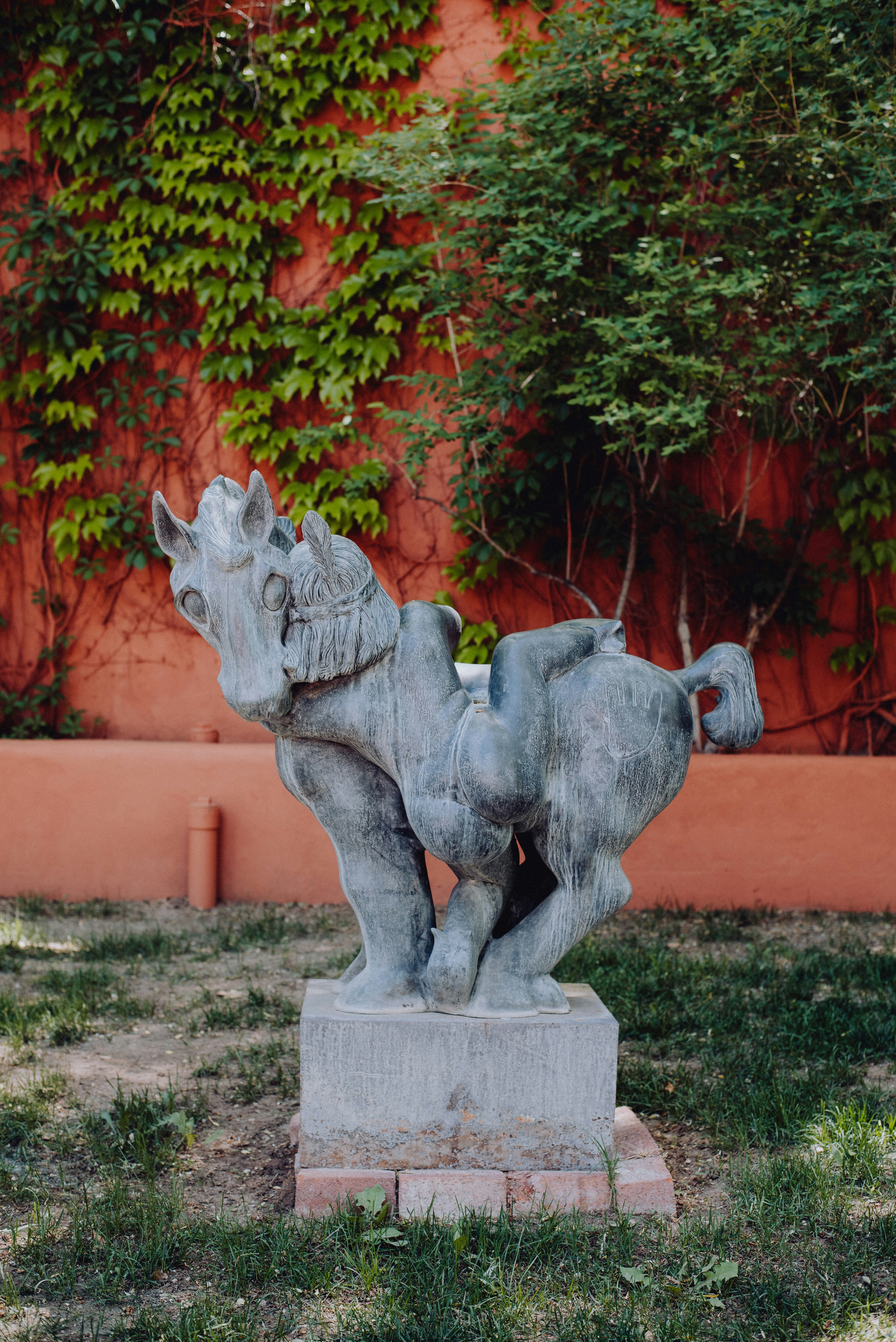 a statue of a horse is in the grass