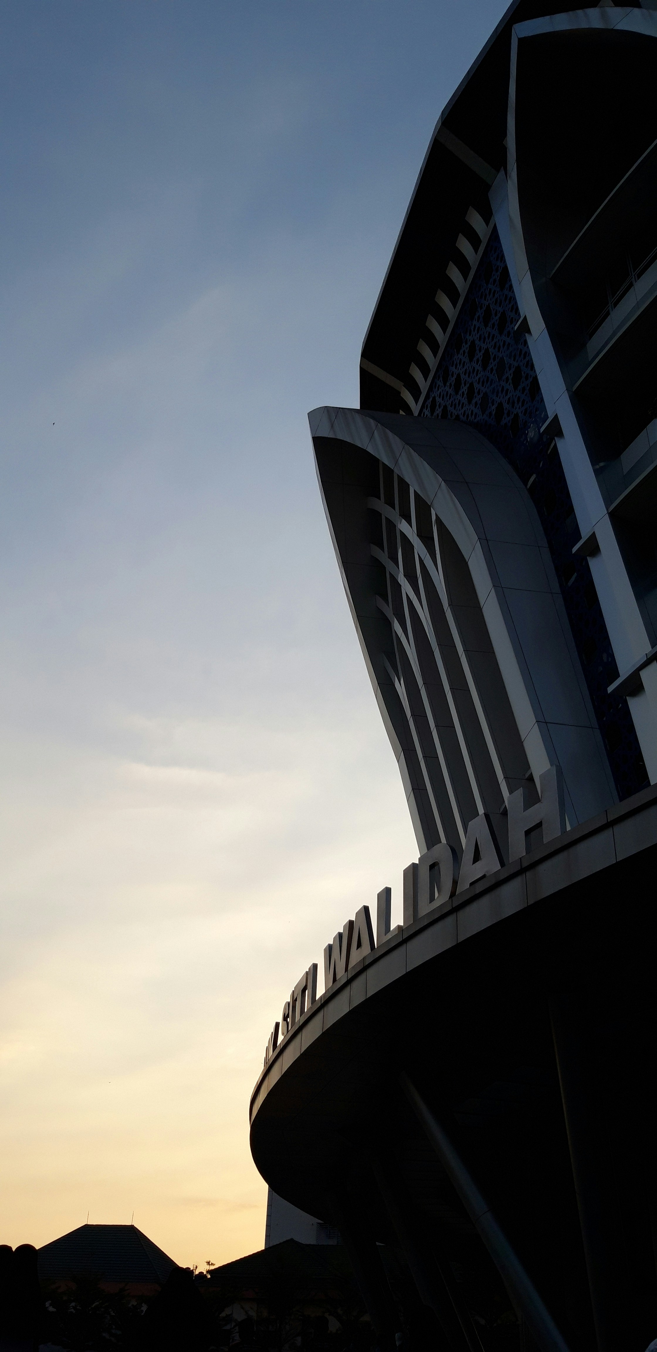 Gedung Induk SIti Walidah | a tall building with a sky in the background