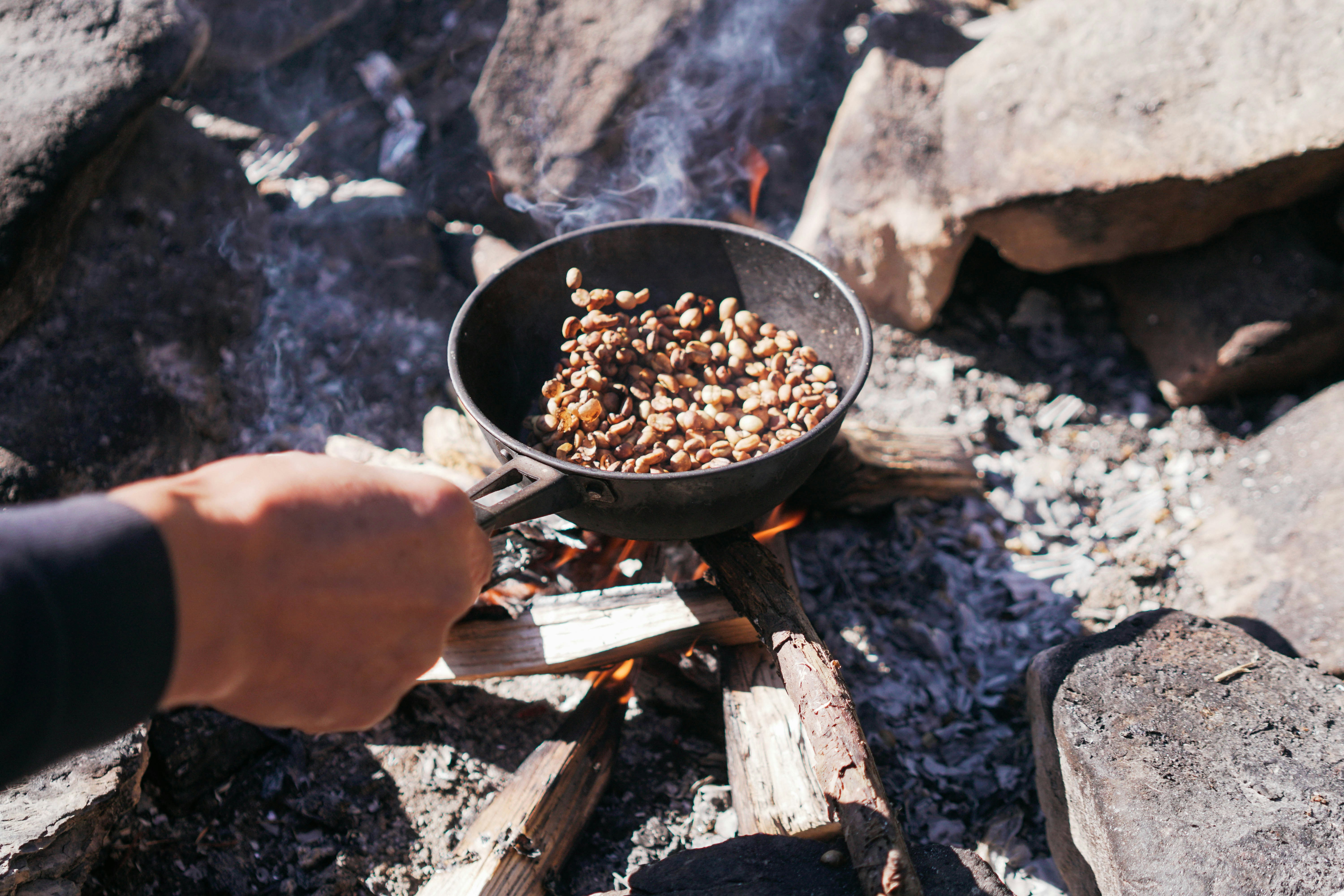 A person is cooking food over a campfire photo – Free Food Image on ...