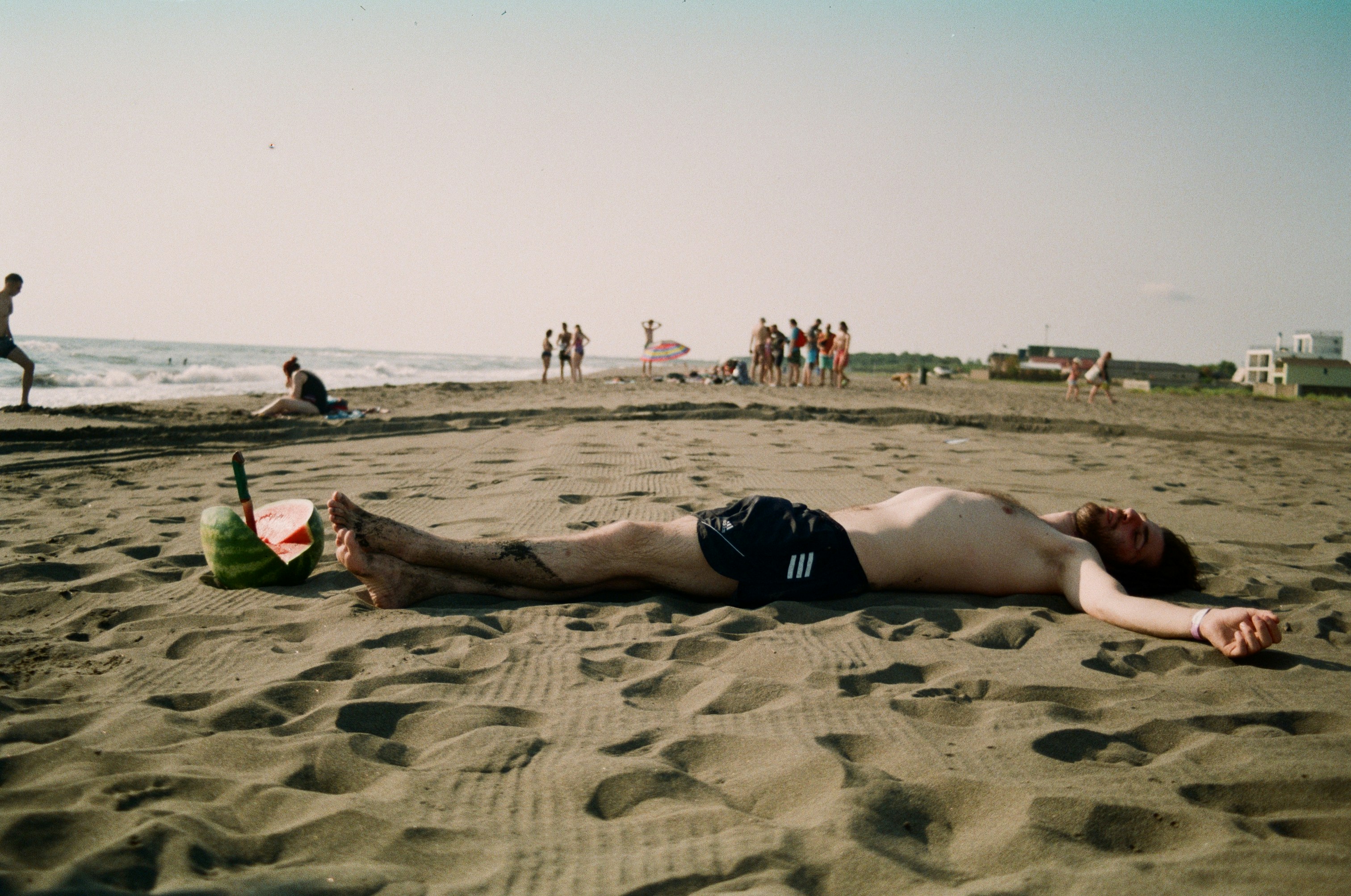 A man laying in the sand on a beach photo – Free Outdoors Image on Unsplash