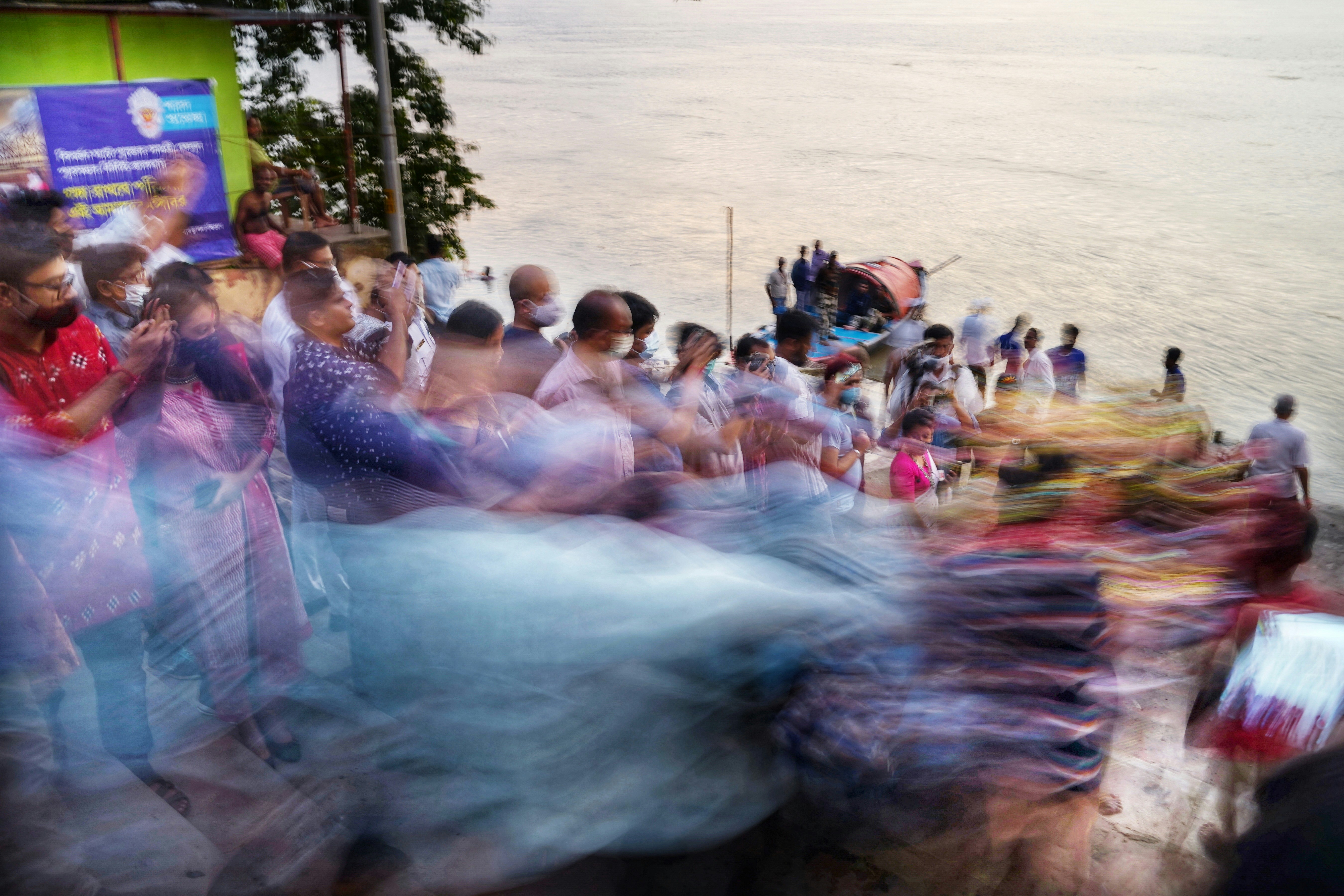 a crowd of people standing next to a body of water