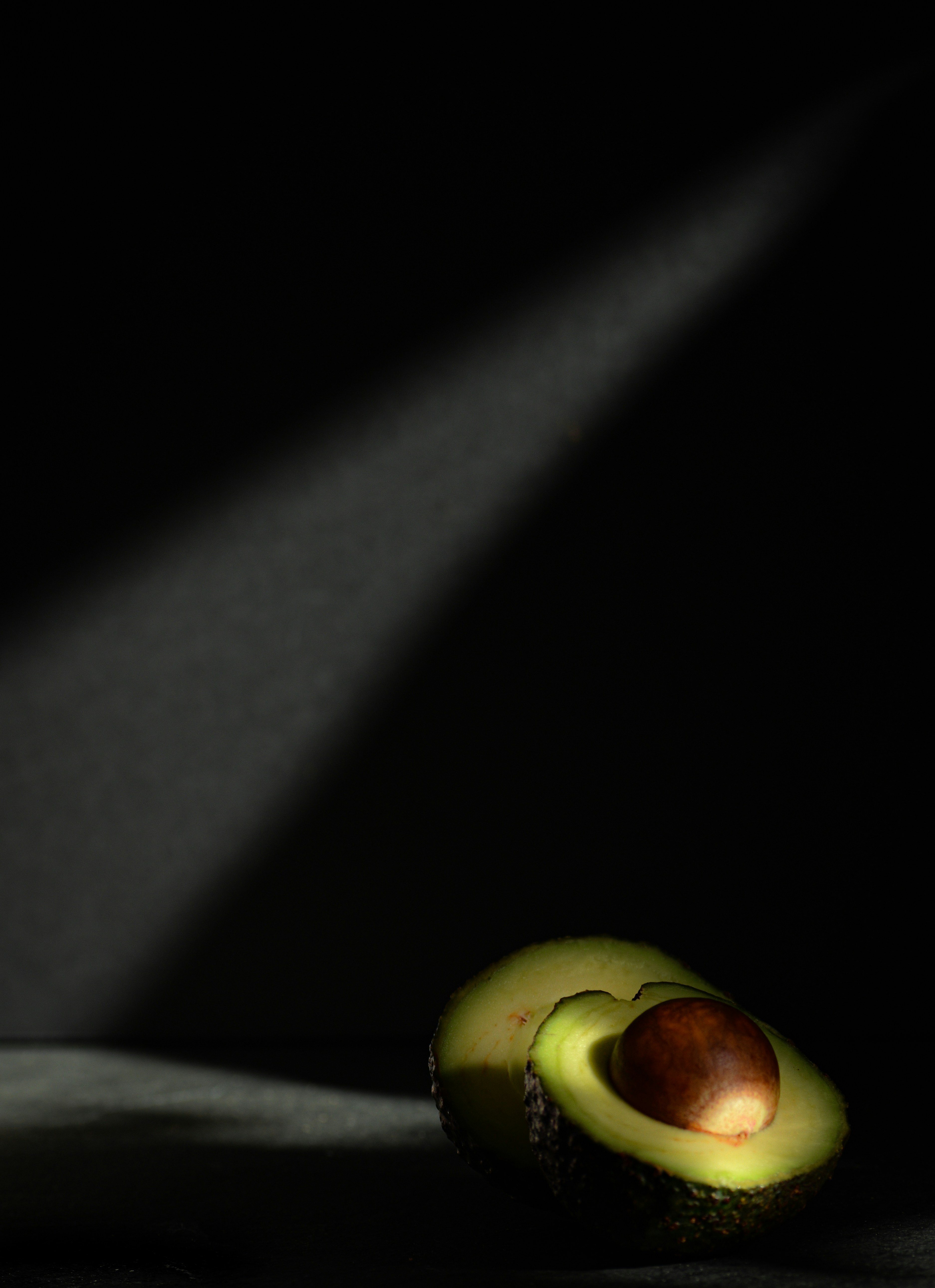 Diagonal Spotlight on a Halved Avocado: Noir Still Life
