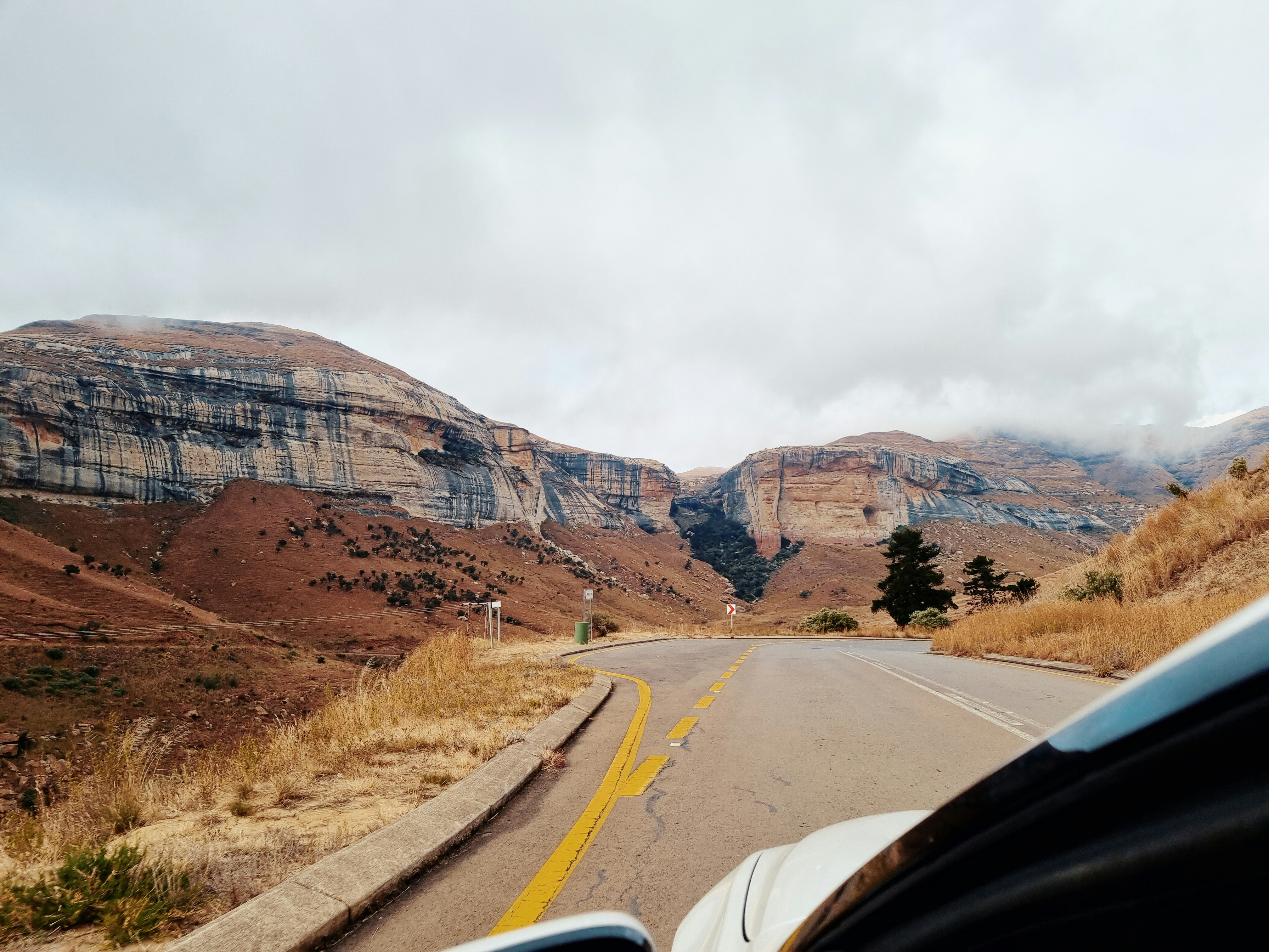 a car driving down a road with mountains in the background
