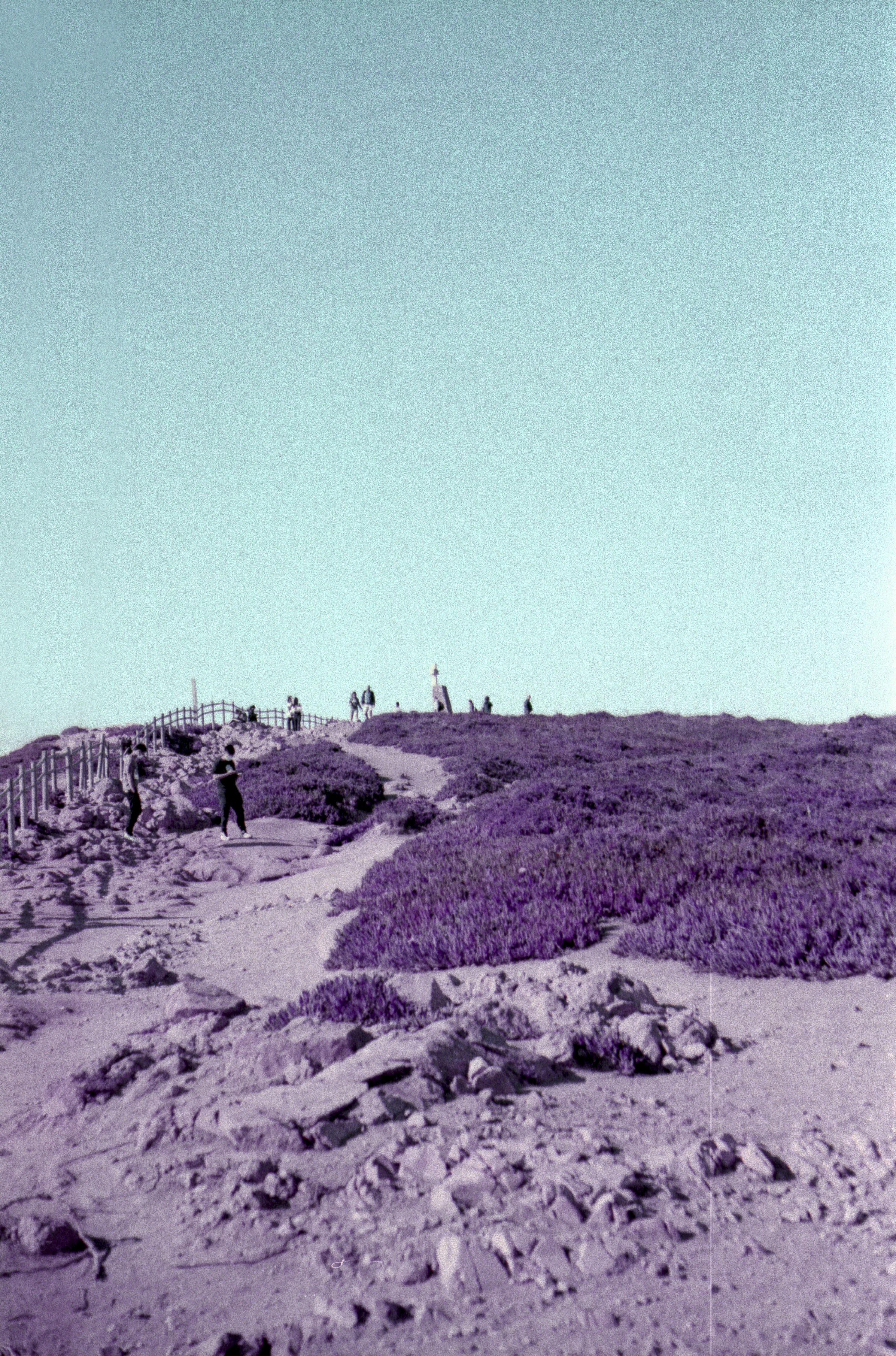 Ridge Path Crowds: A Distant Ascent Beneath a Cyan Sky