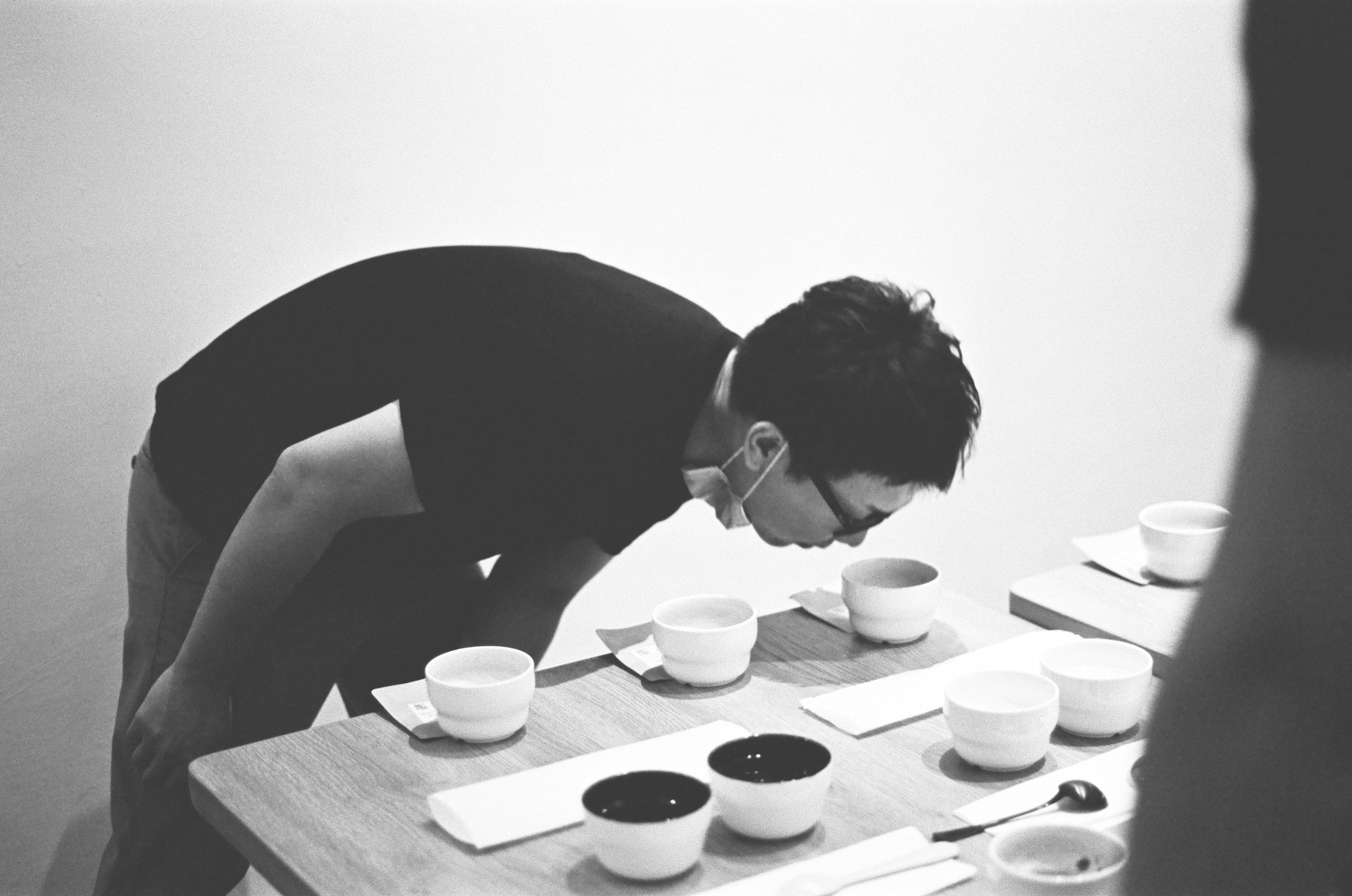 A person bending over a table with cups on it photo – Free Human Image ...