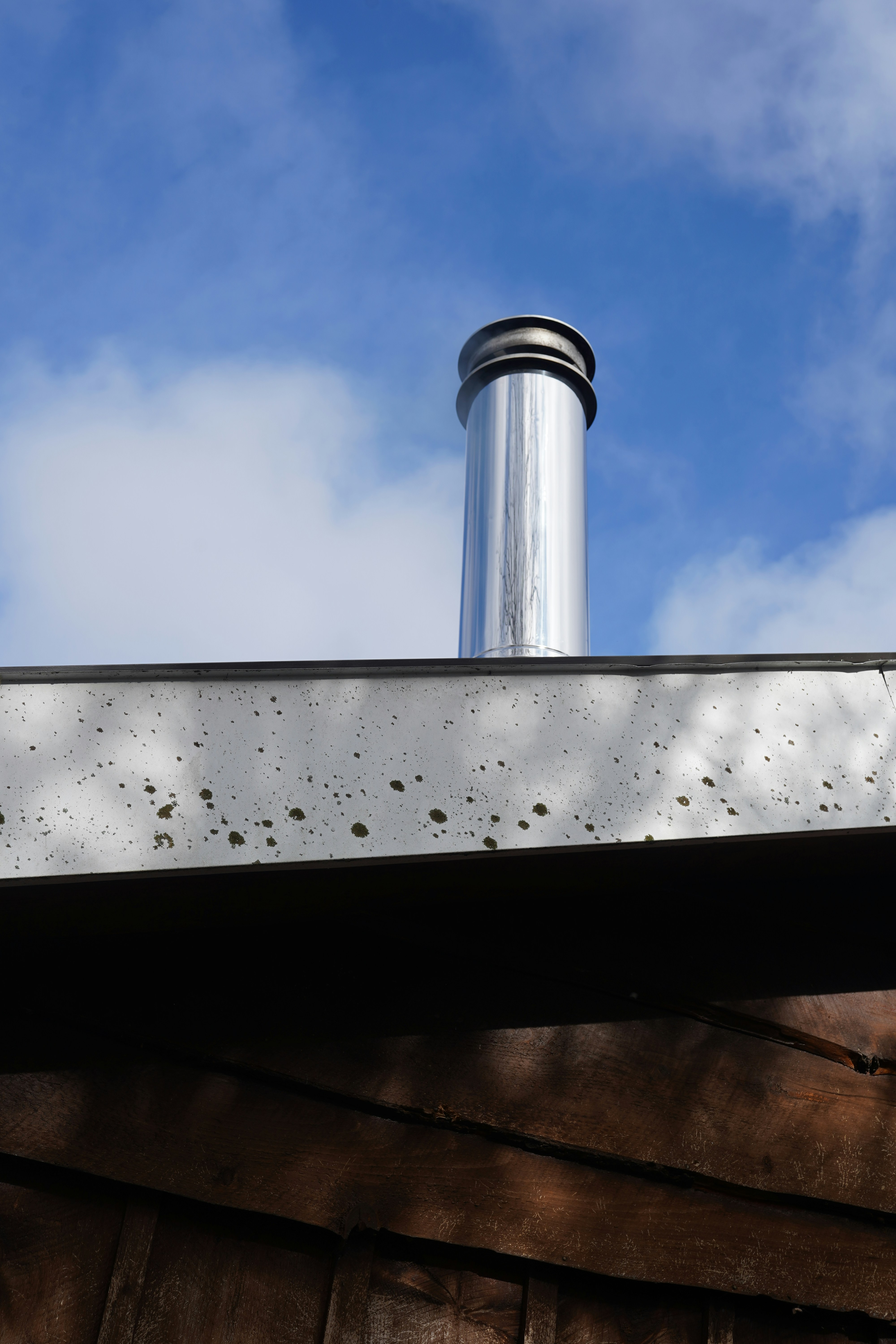 A metal chimney on top of a building photo – Free Window Image on Unsplash