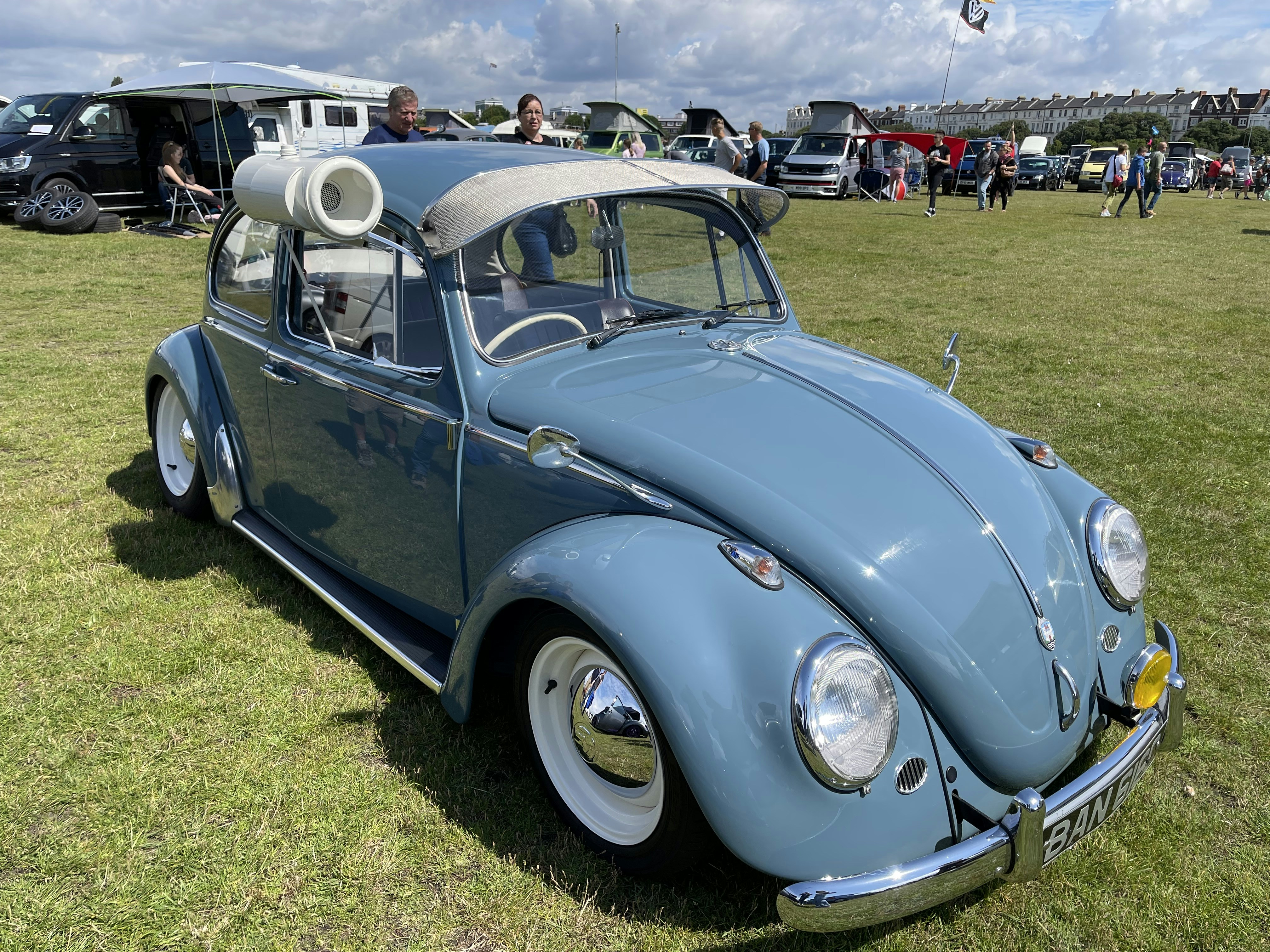 A blue vw bug parked on top of a grass covered field photo – Free Car ...