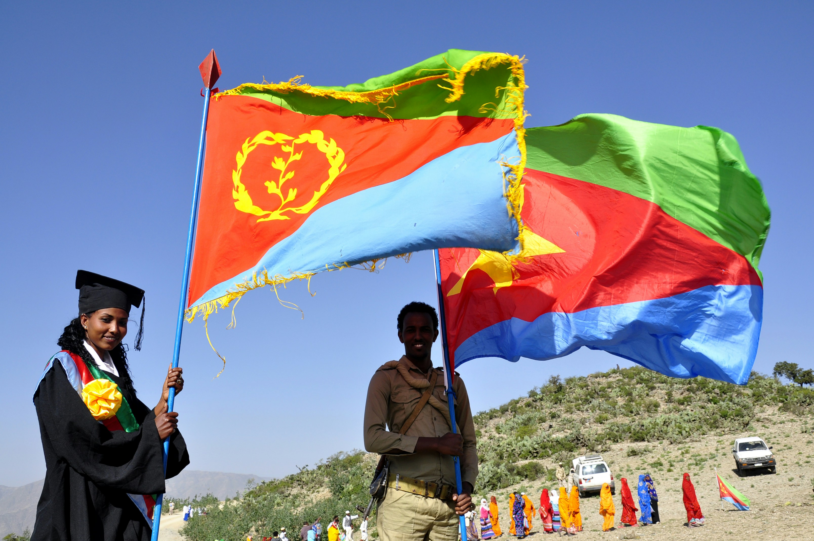 Foto Un par de personas que están sosteniendo algunas banderas – Imagen ...
