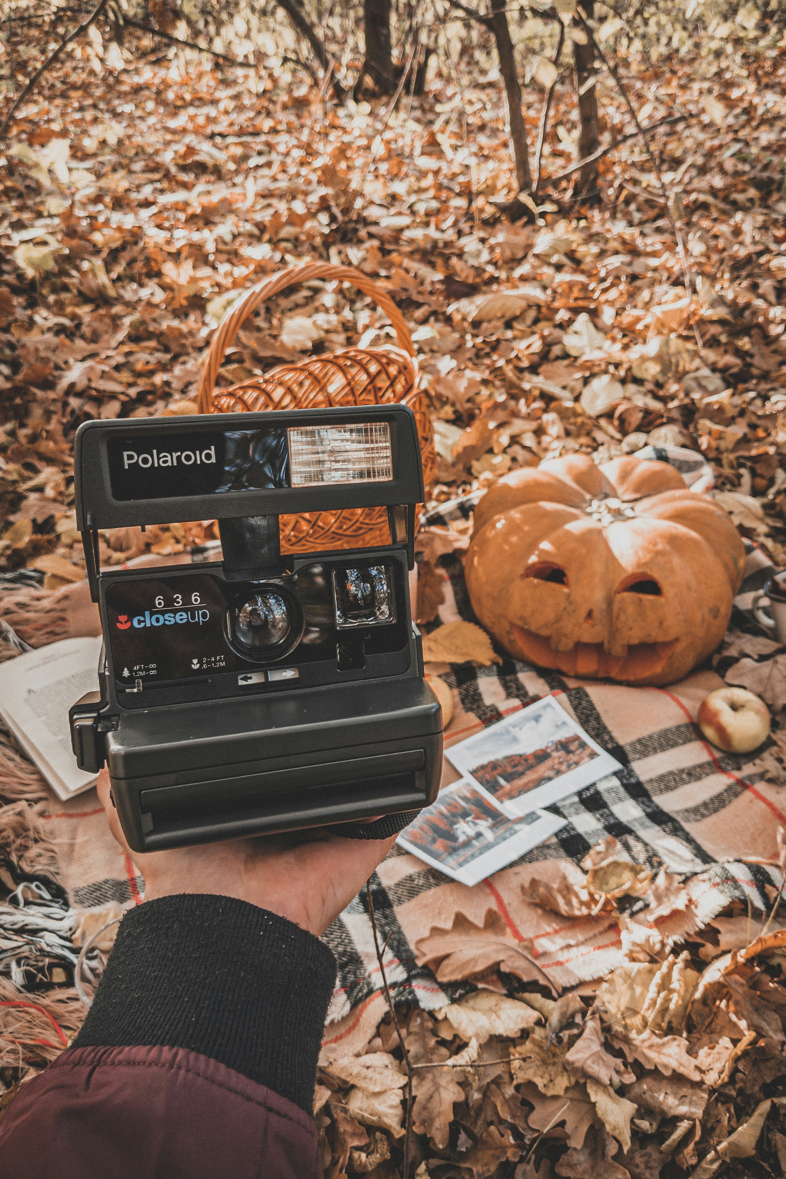 a camera sitting on top of a blanket next to a pumpkin