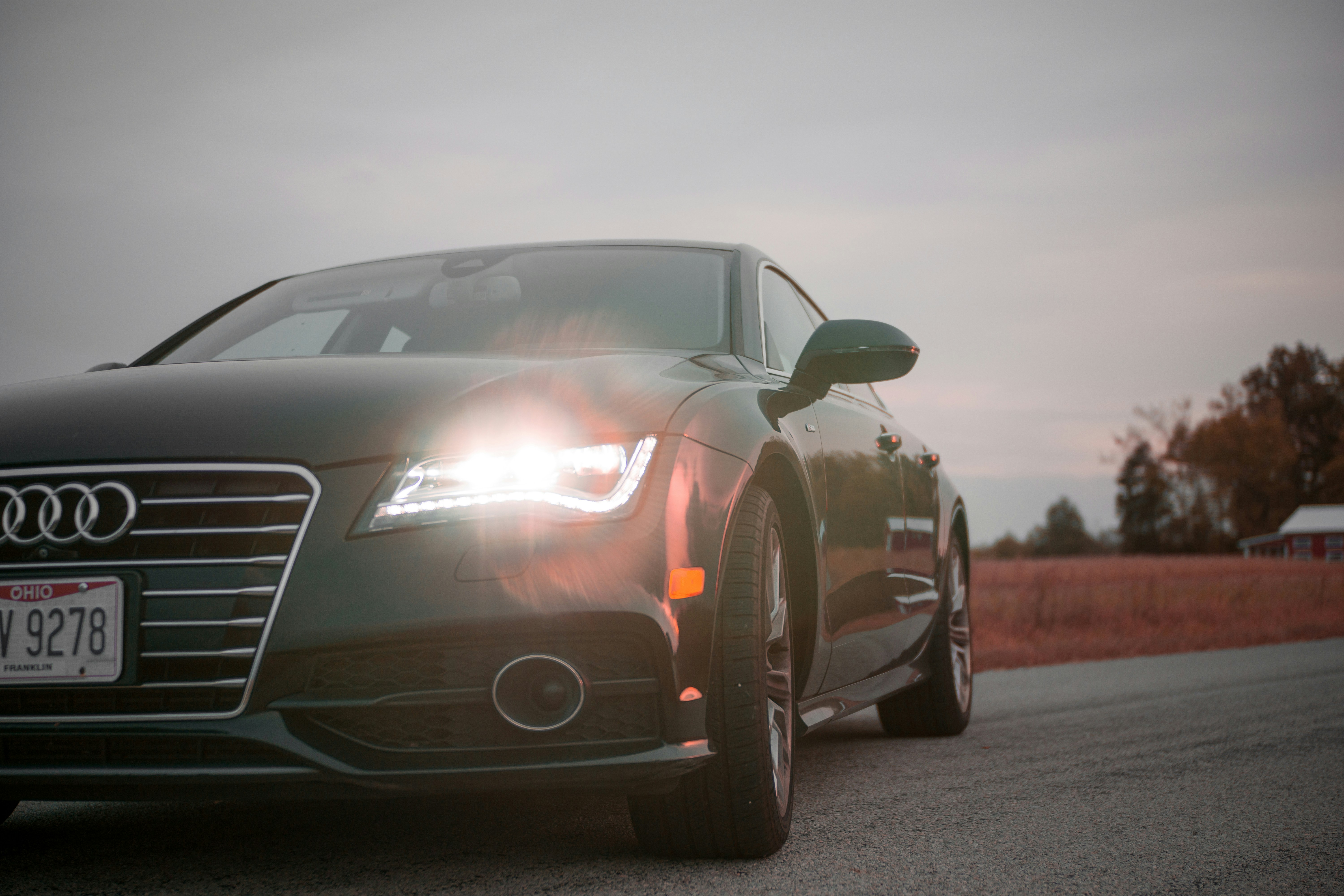 Dusky Glare on the Grille: An Audi sedan on a quiet rural road