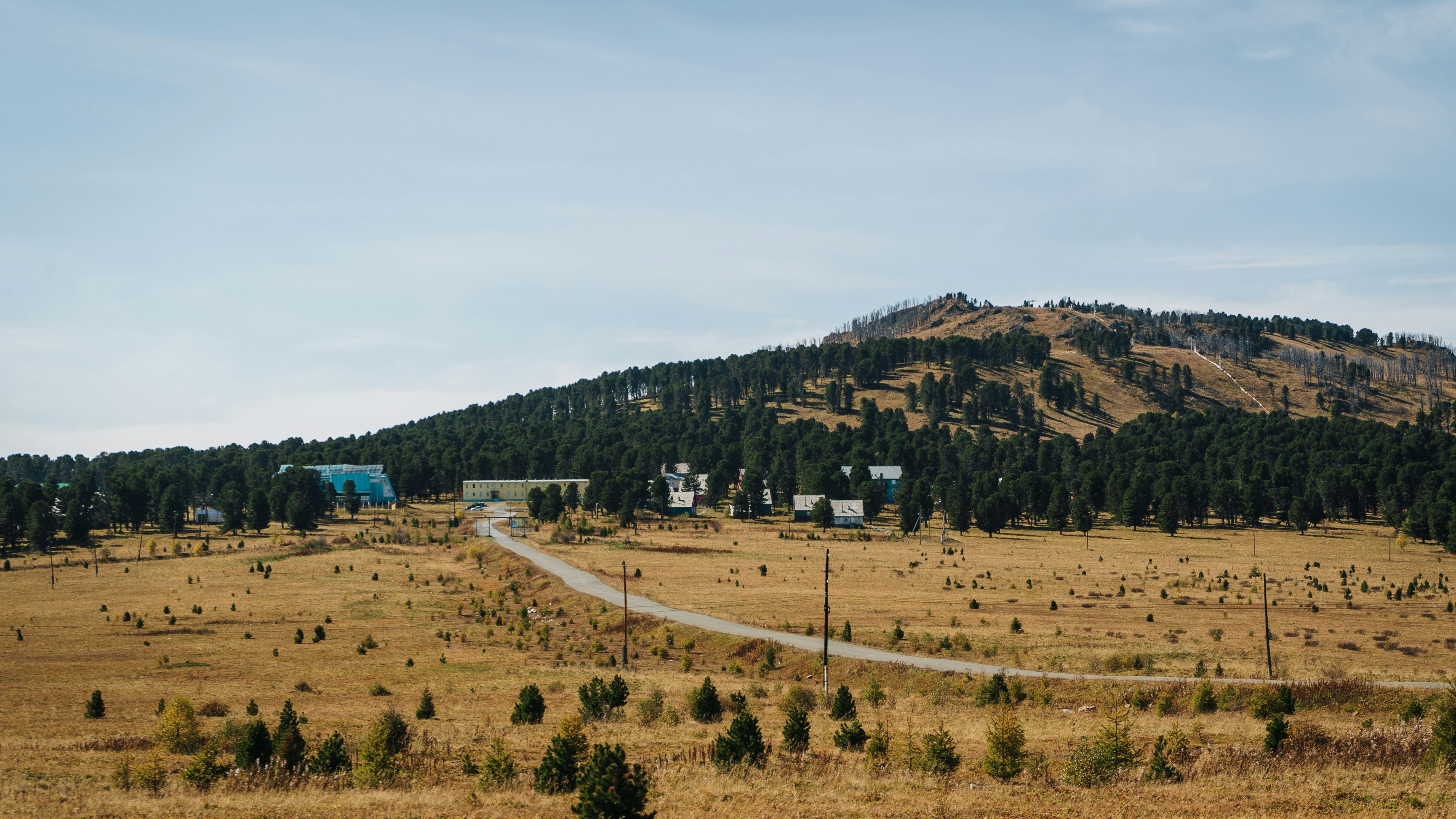 Dust Road Toward a Hilltop Farmstead