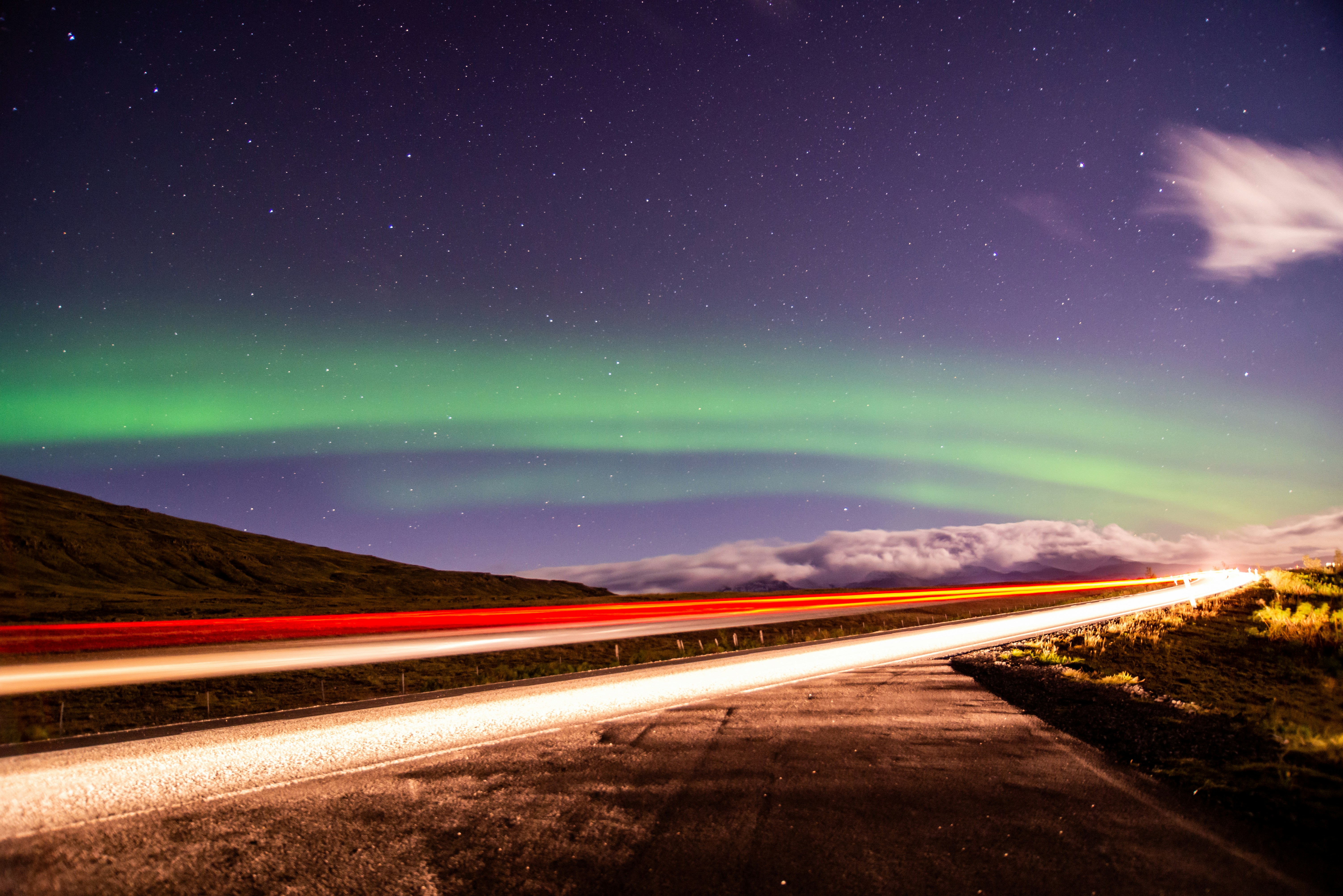 Aurora over the Road: Light Trails Beneath the Green Arc