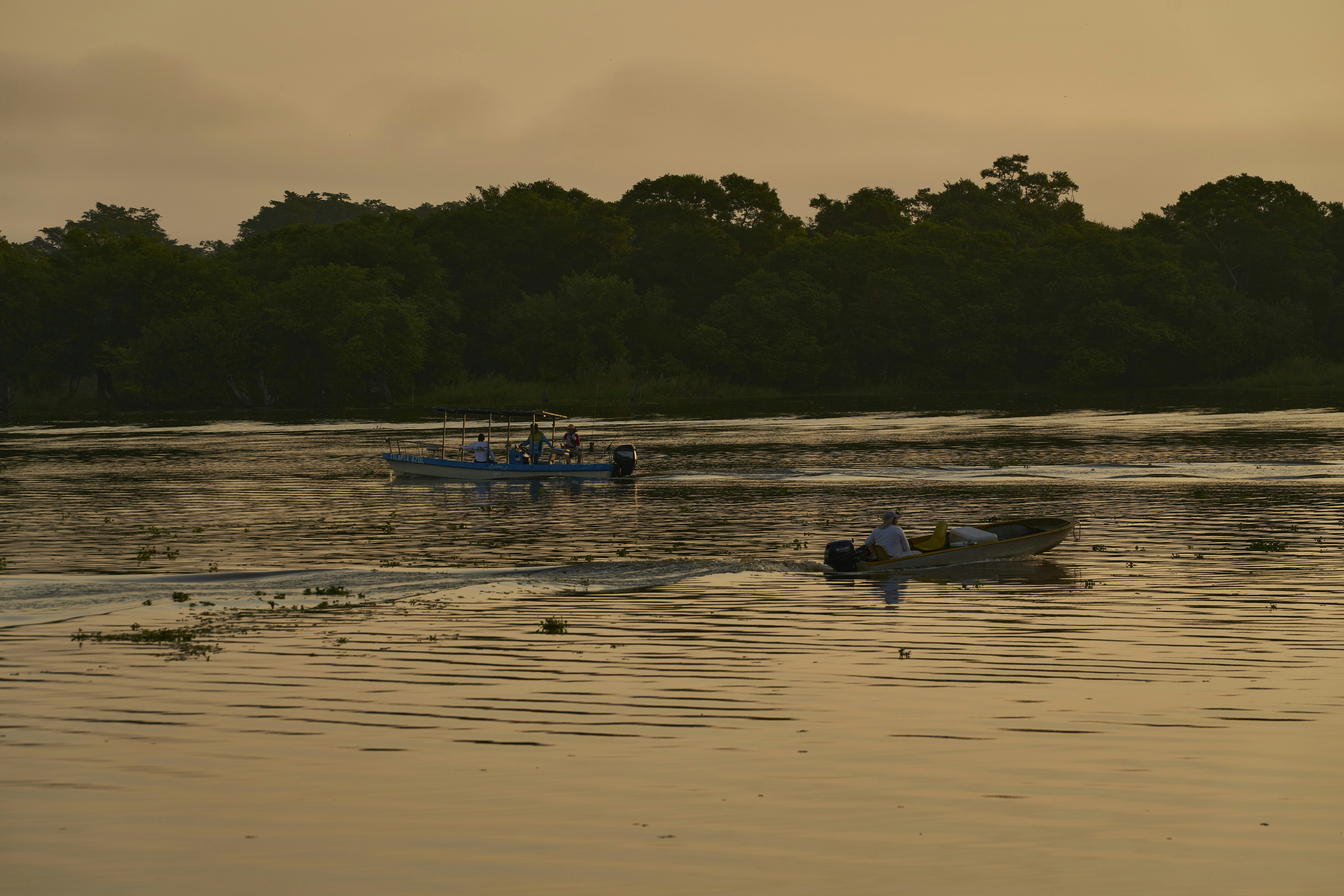 Dusk on the River: Twin Boats Sketch Golden Ripples Across Quiet Water