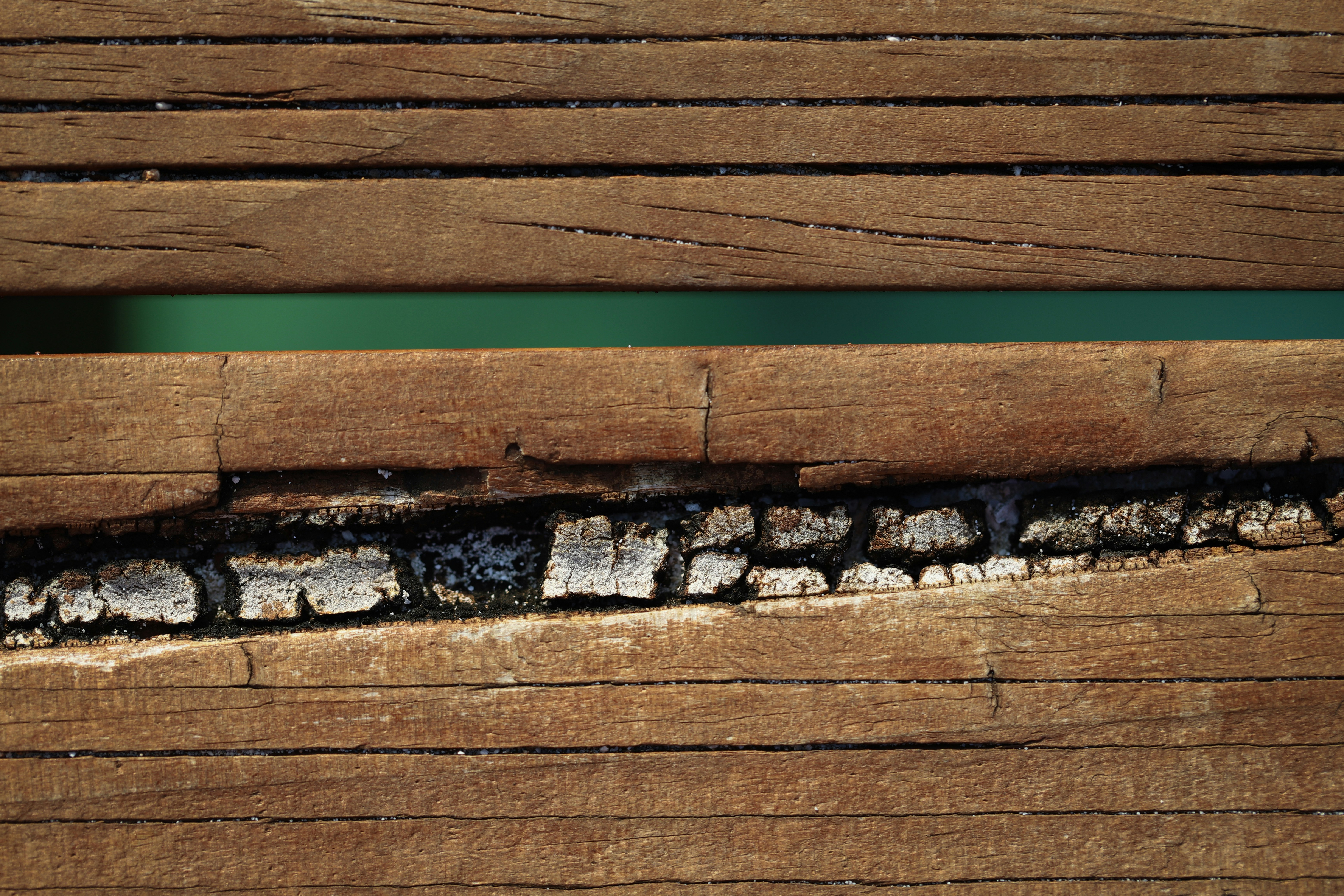 Grainline at the Seam: A Close-Up of Weathered Wood and Pebble Cracks