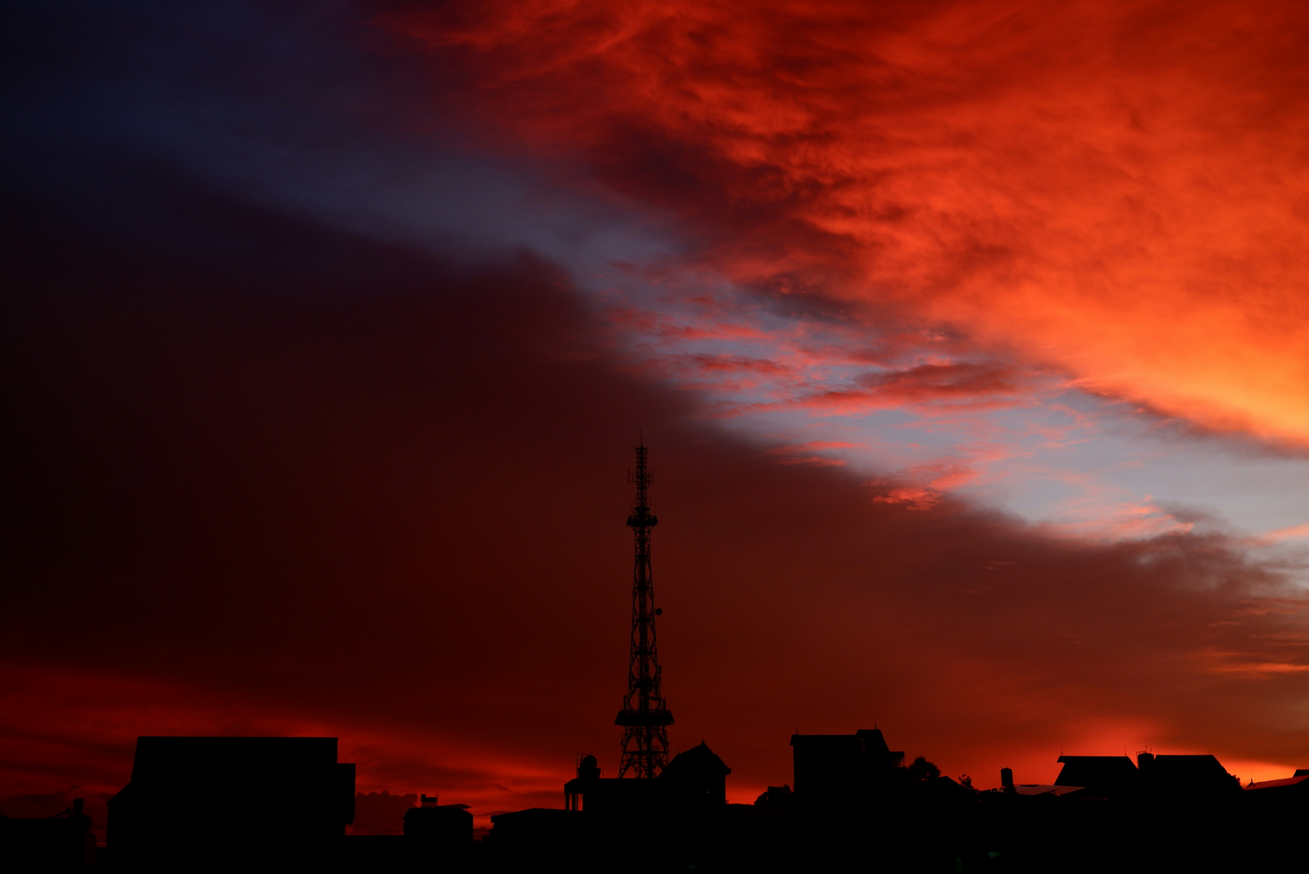 A red and blue sky with a tower in the distance photo – Free Nature Image on Unsplash