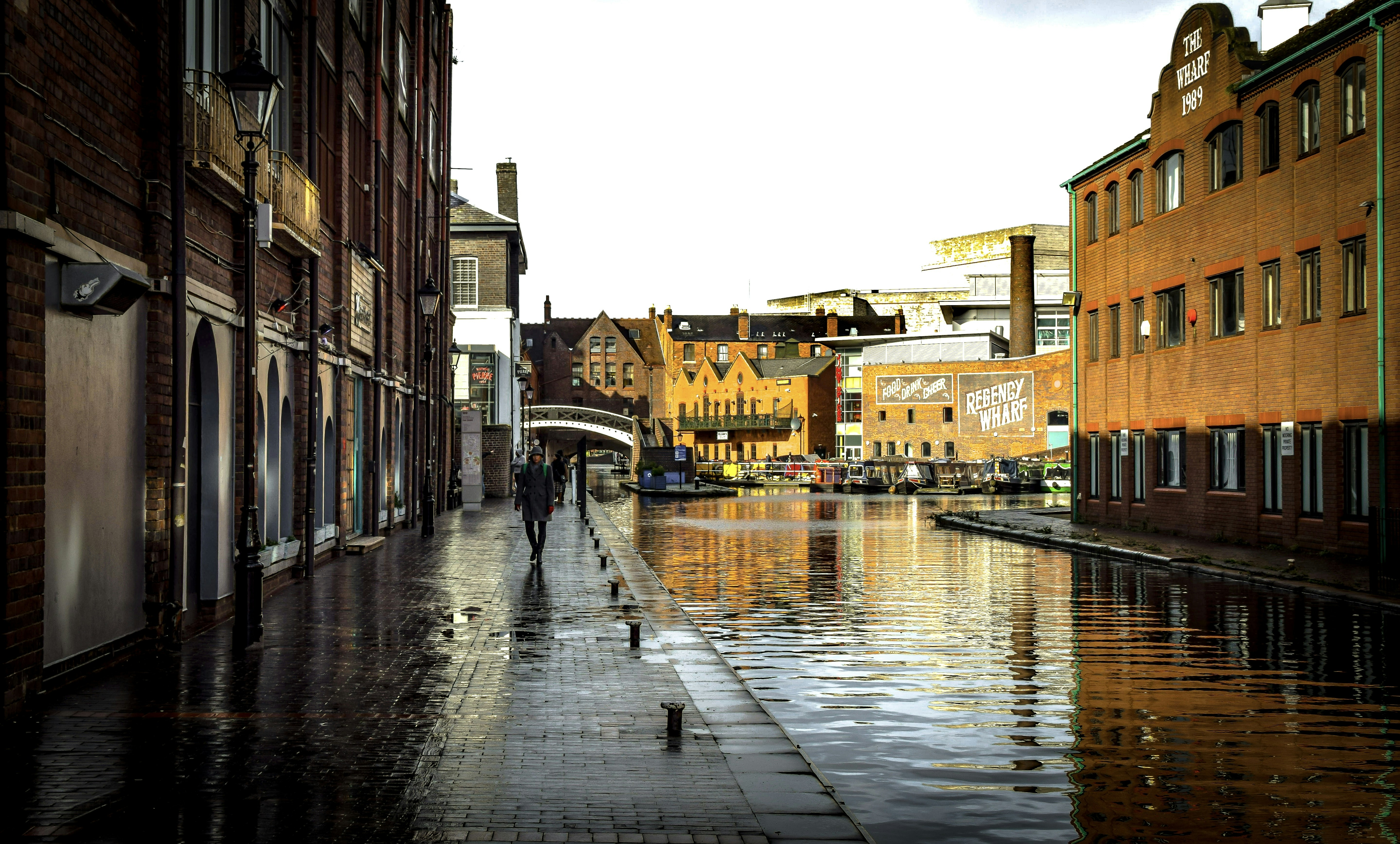 A wet Gas Steet… | a wet city street with people walking on it