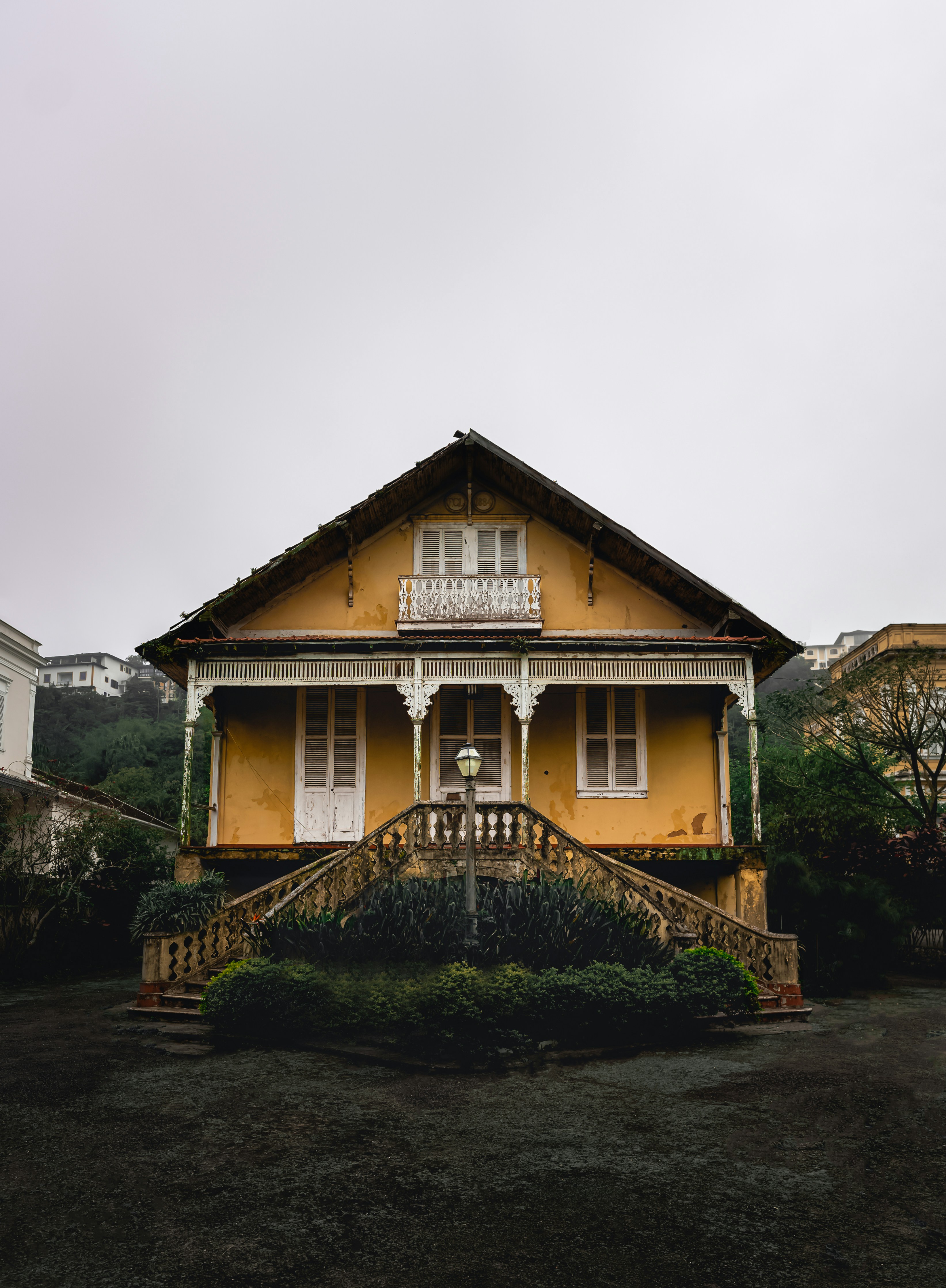 Symmetrical yellow villa with ornate veranda and central staircase