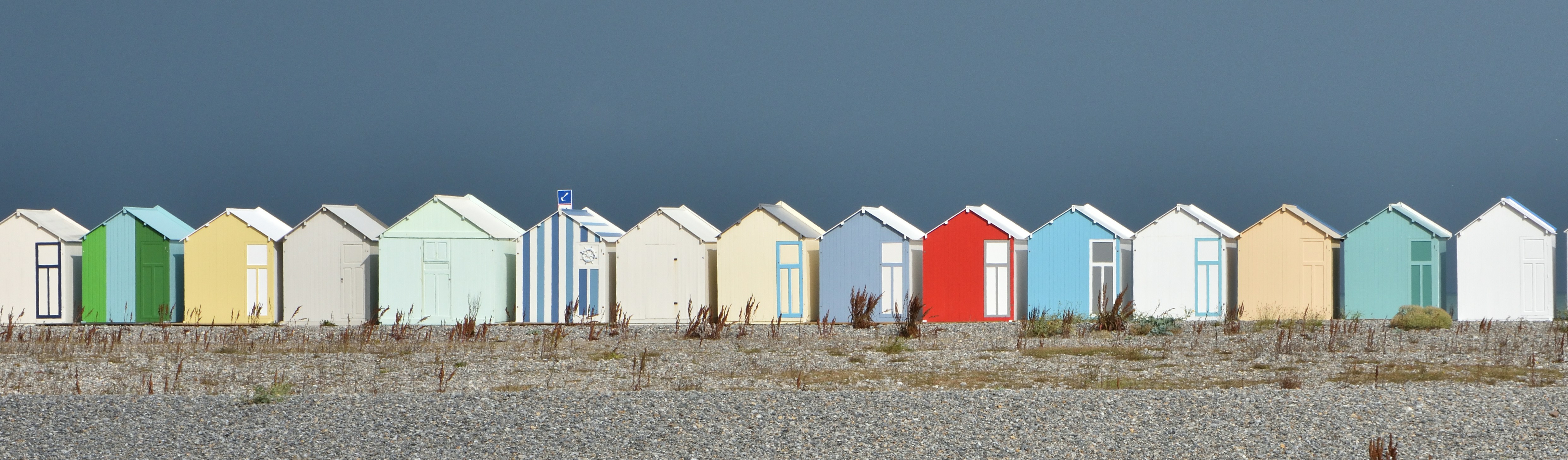 Colourful Beach house row in north of france under stormy sky
