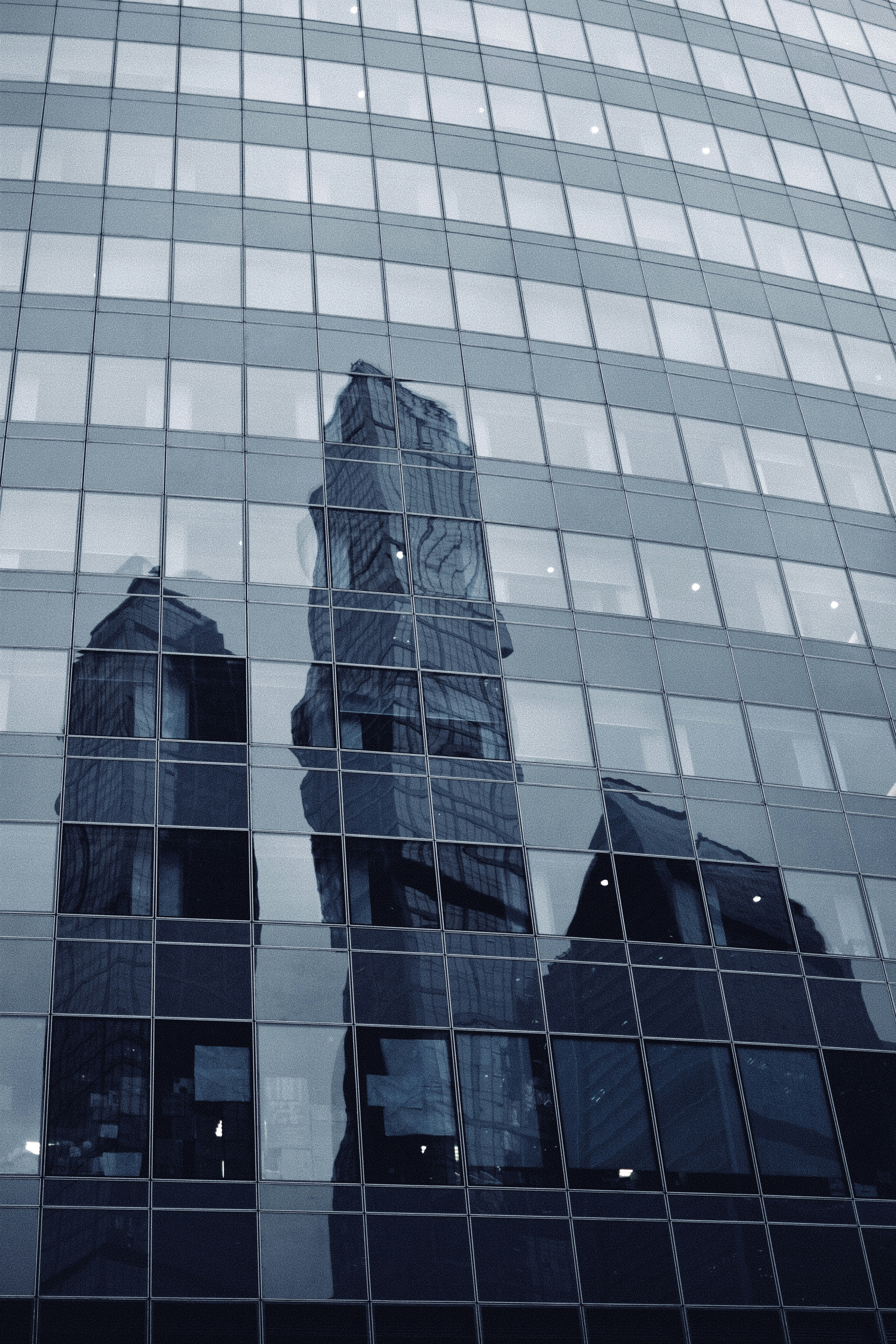 Abstract reflections of skyscrapers captured on a glass facade, showcasing the interplay of architecture and light.